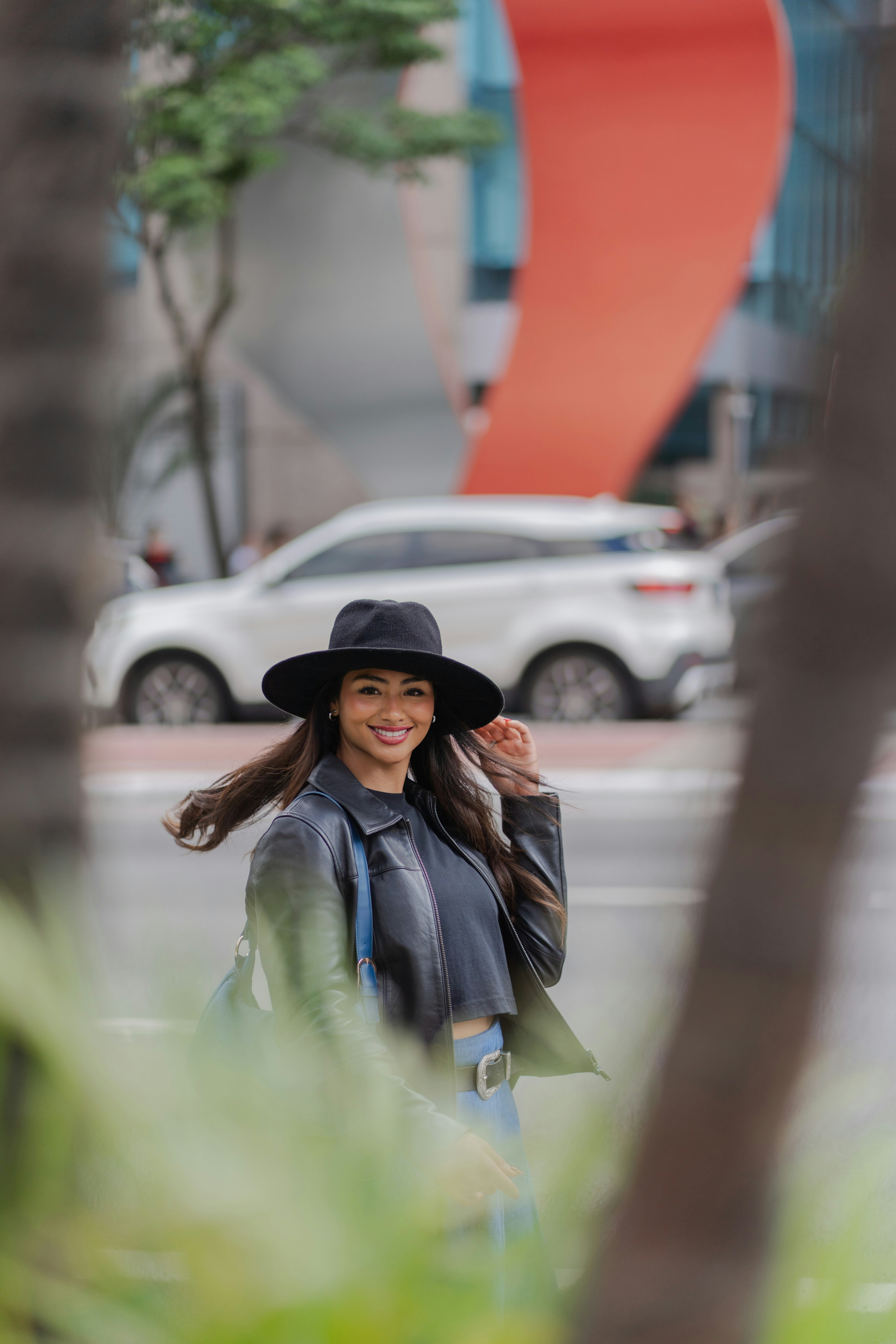 City Portrait: A Confident Smile Beneath a Wide-Brimmed Hat