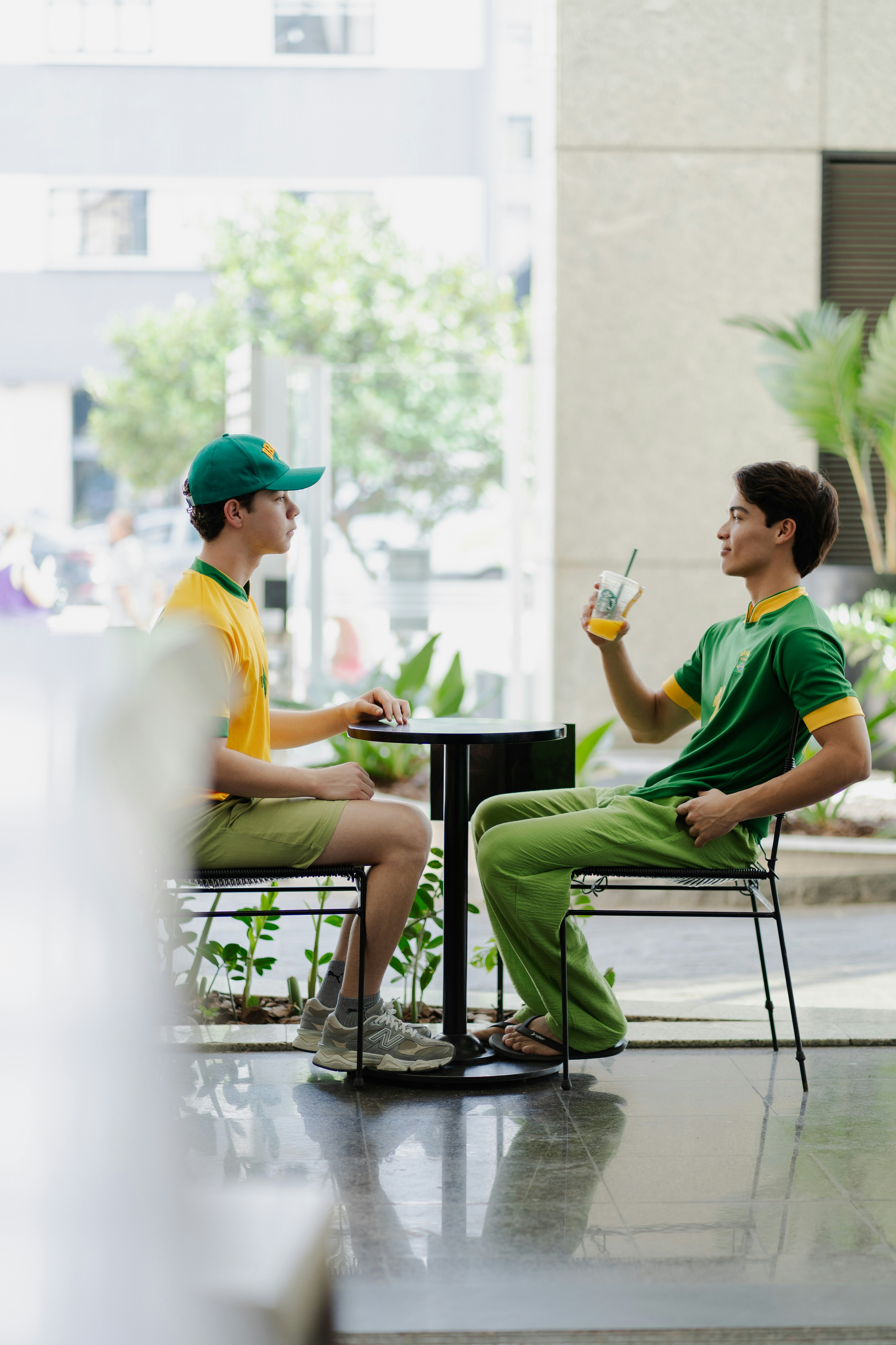 Casual Coffee Break Between Two Friends in Bright Courtyard