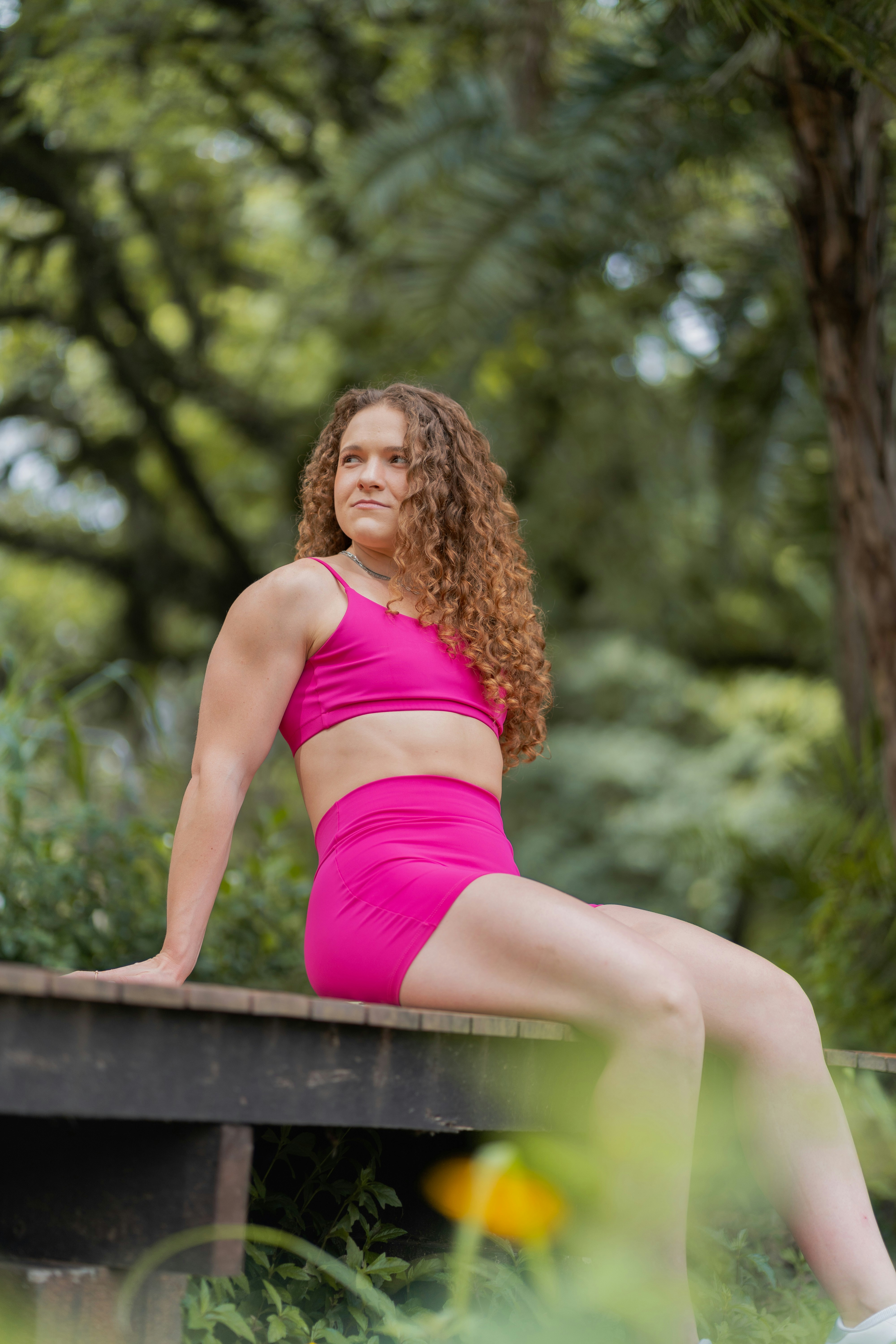 Vivid Pose in a Pink Ensemble Amid Green Canopy