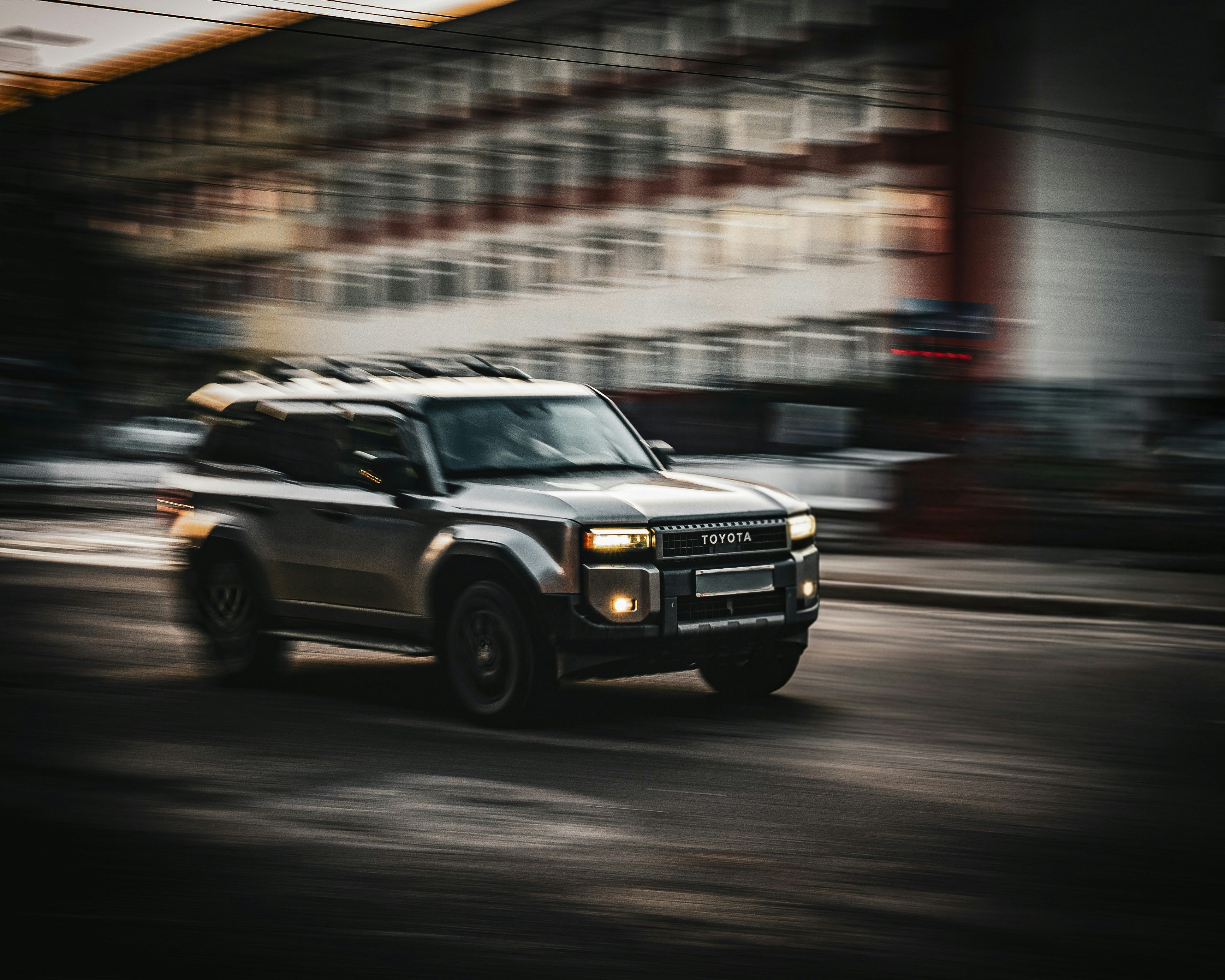 Deserted Track: A Toyota SUV Speeds Through a Blurred City Scene