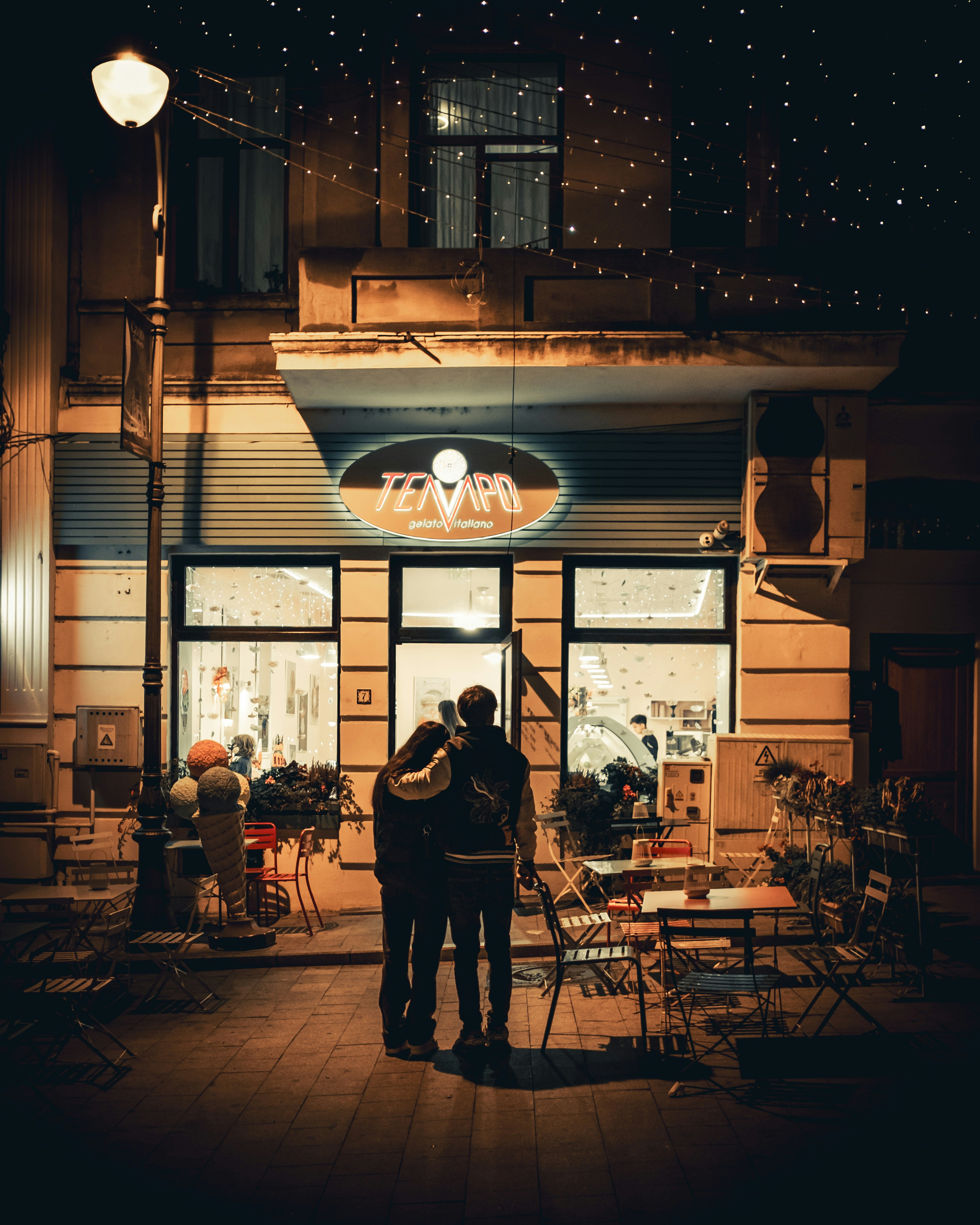 Night at the Lantern Café: Embrace Under the Sign