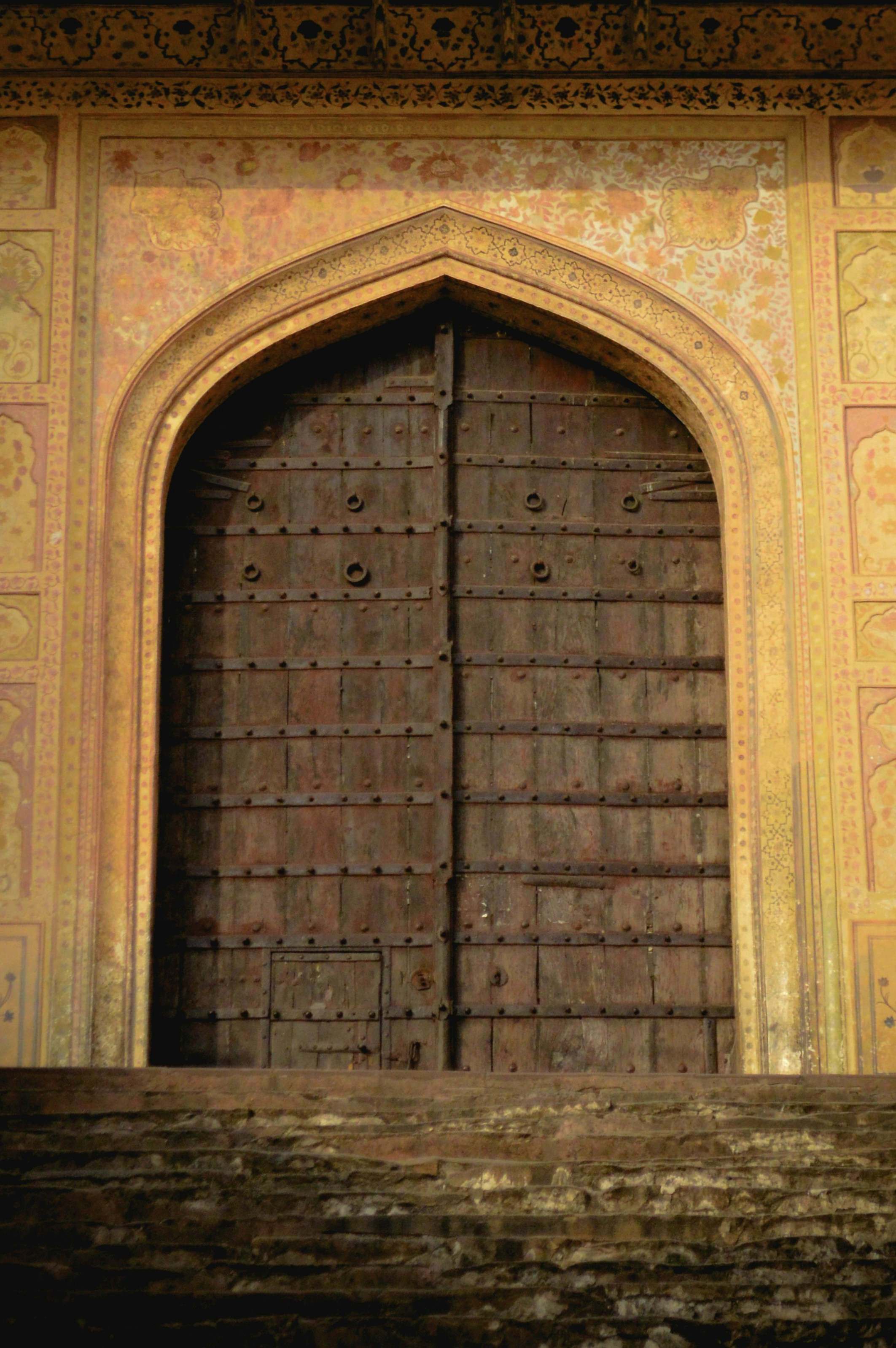 Stone Portal: An Ornate Doorway Framed by Fading Gold and Patterned Architecture