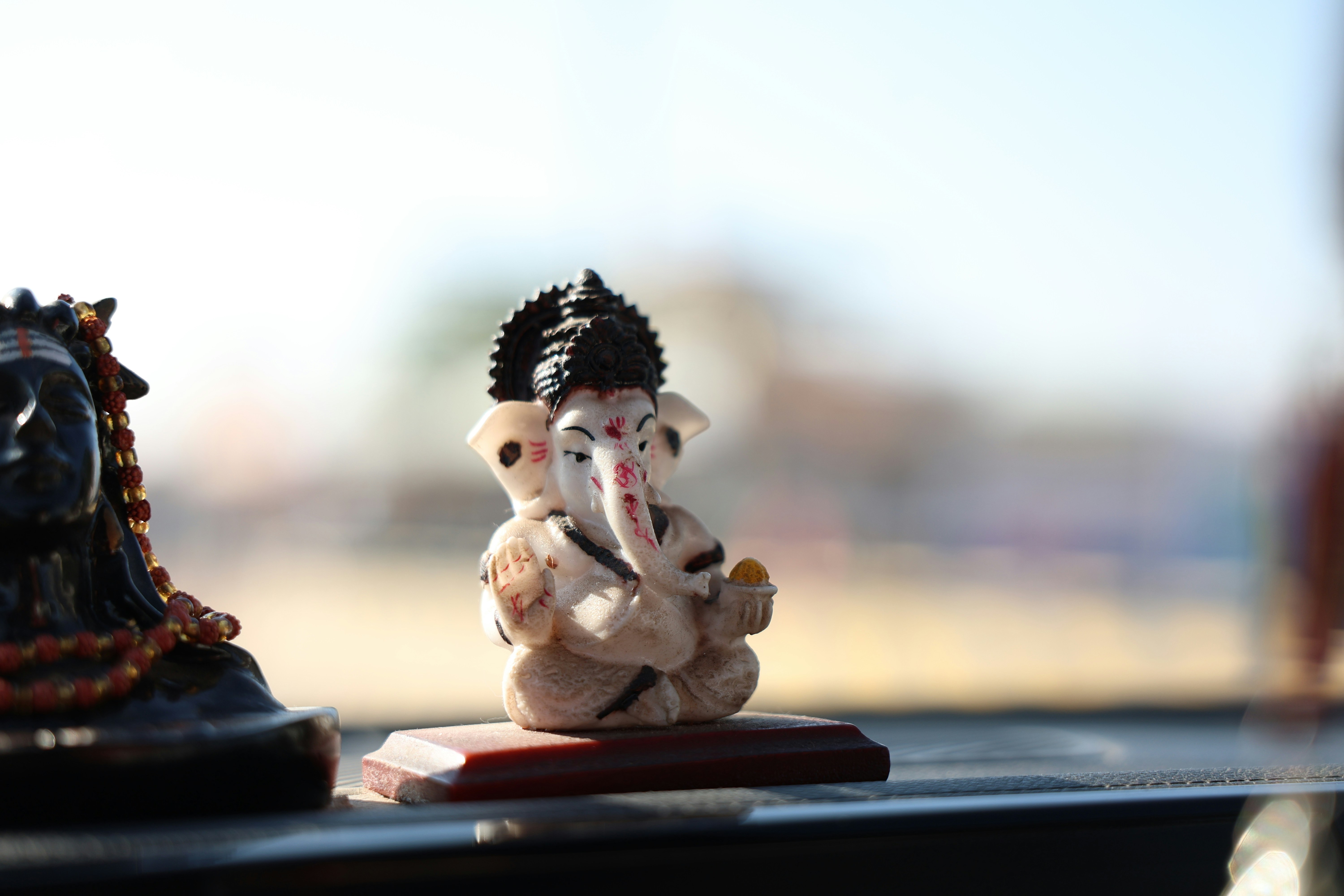 Tiny Ganesha on a Wooden Slab: Quiet Figurine in Soft Backlight
