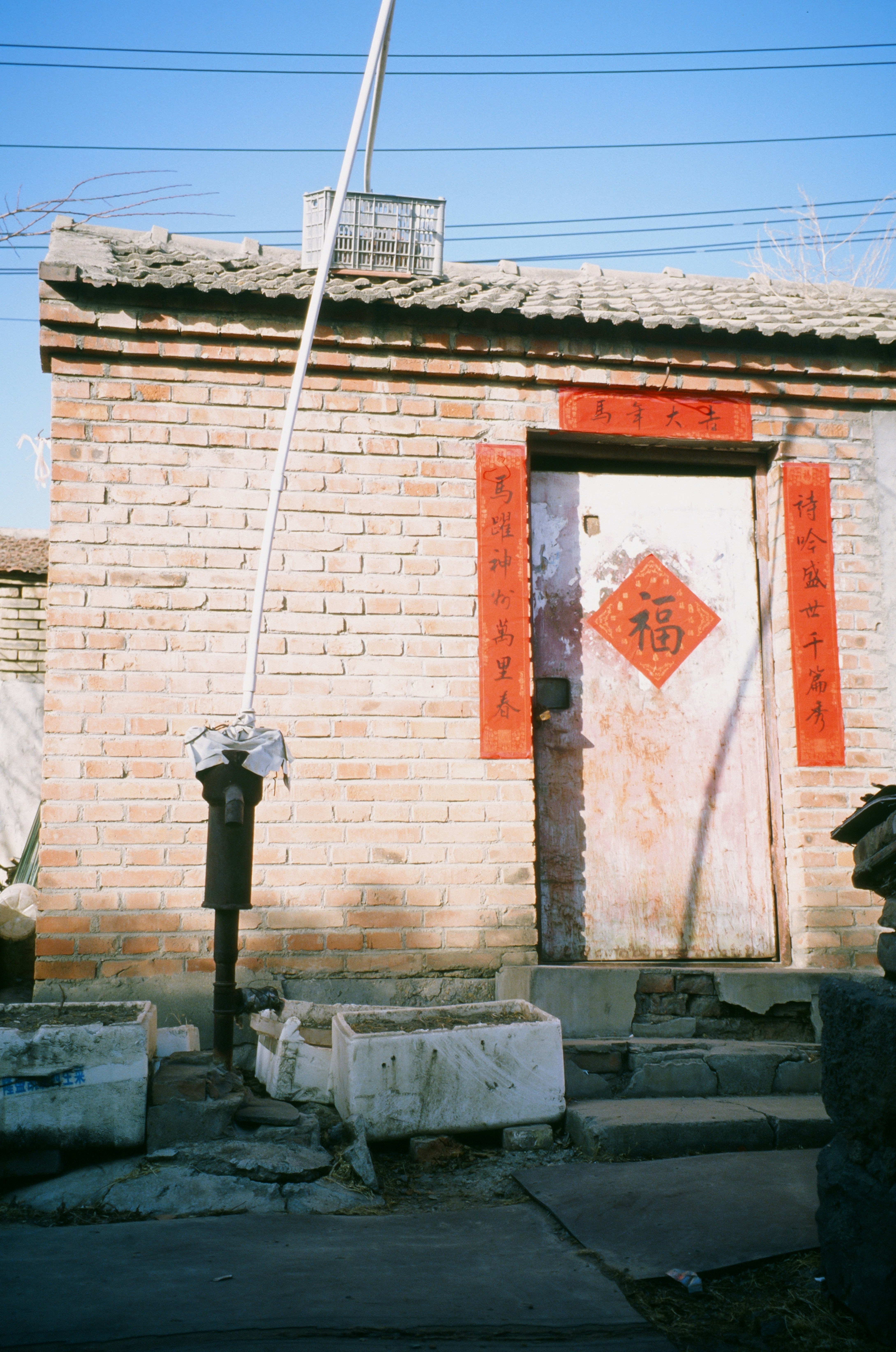 Brick building with red chinese new year decorations on door.