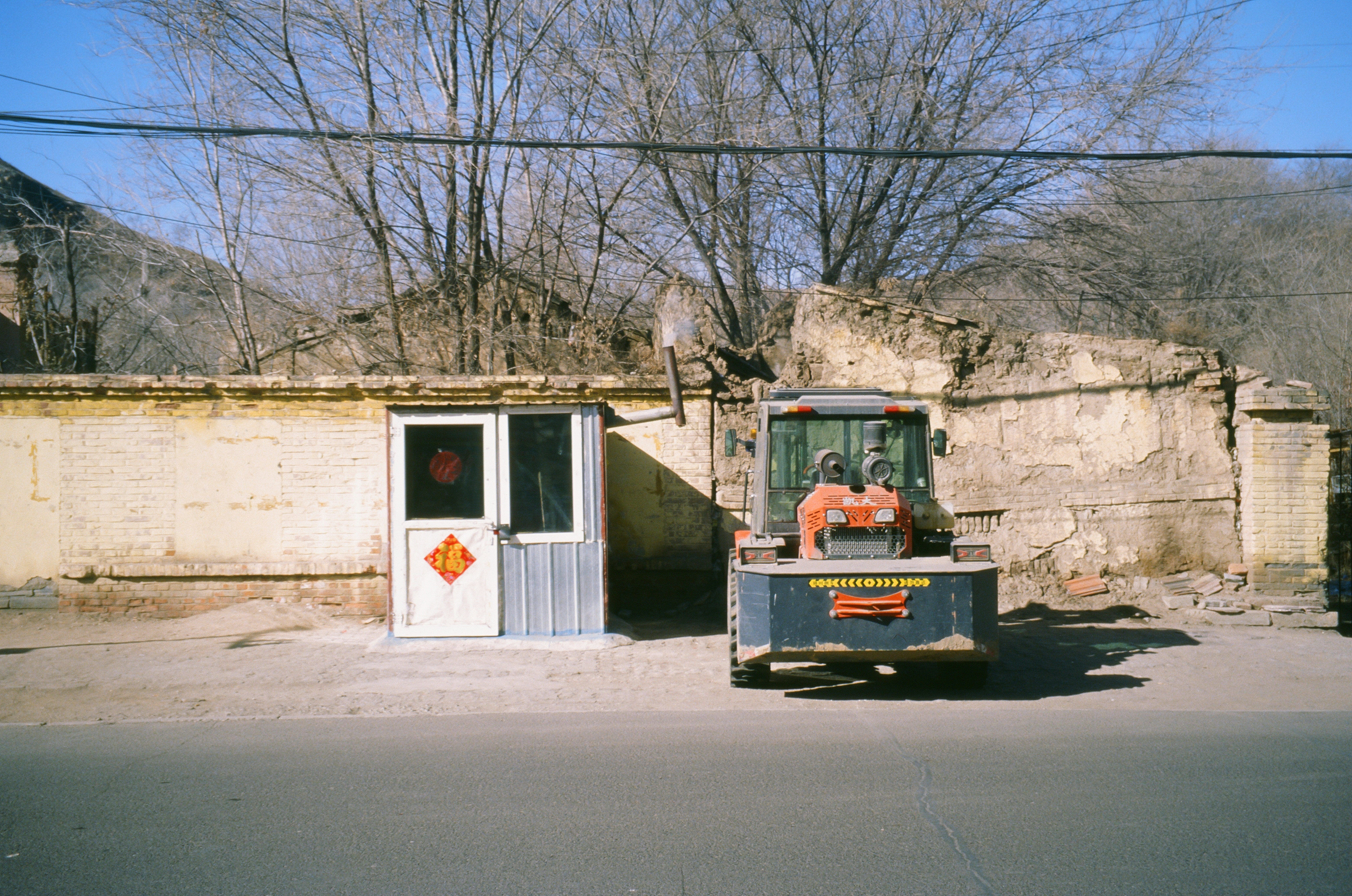 Small building and a road roller on street.