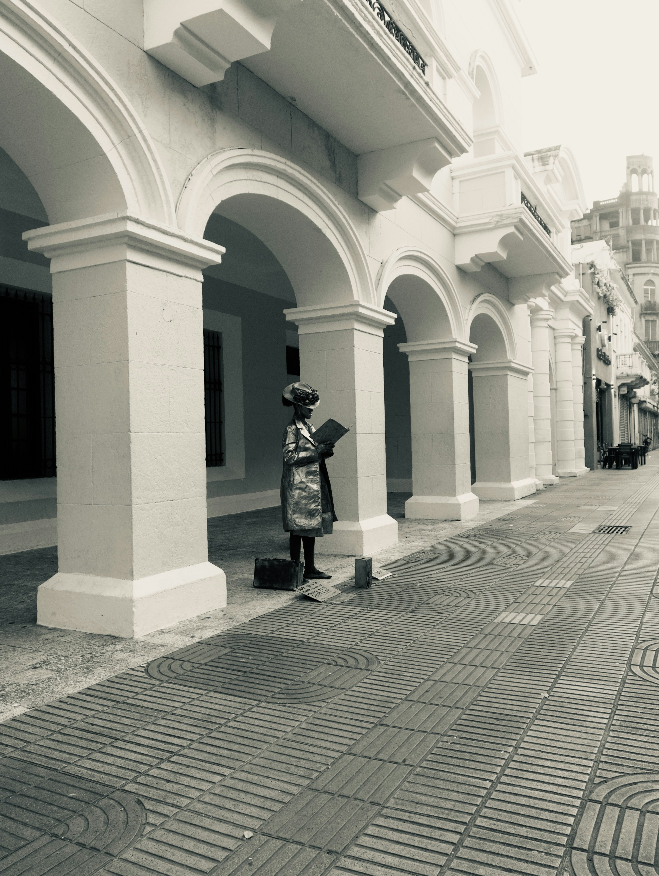 A statue of a person reading under an archway.