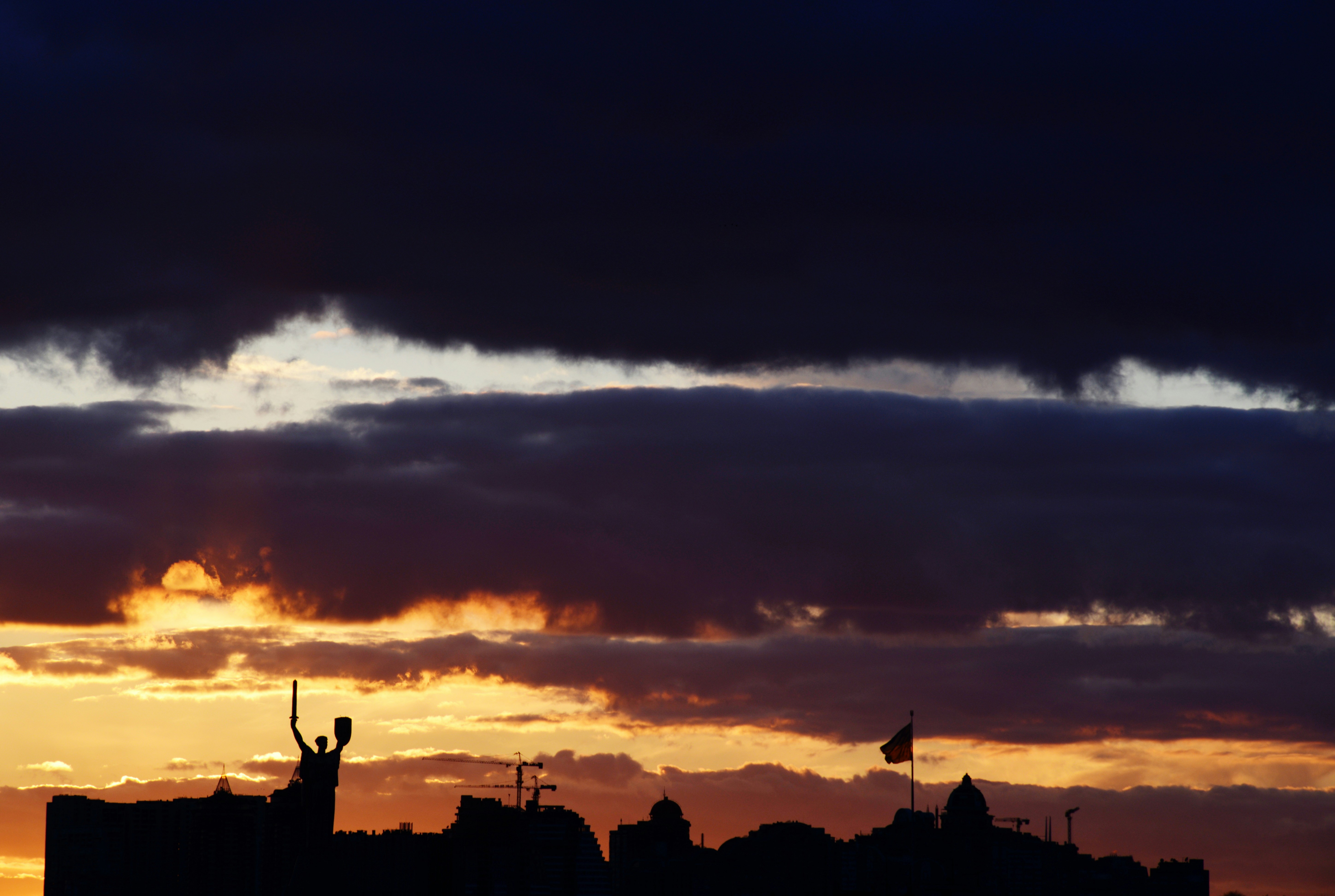 Silhouette of a dusk skyline: raised silhouette against a fiery horizon