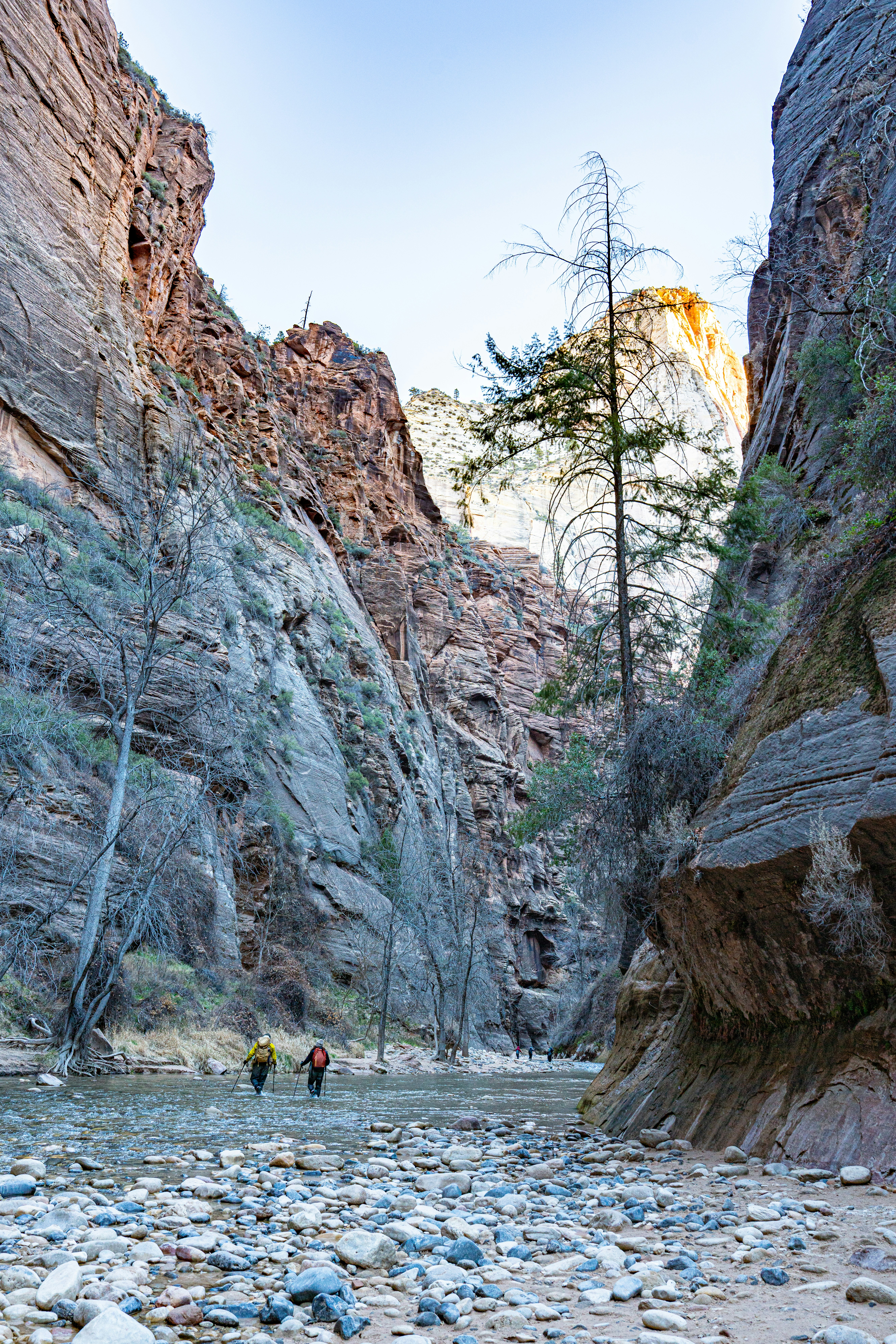 Rugged Gorge Trek: Two Climbers Crossing the Riverbed Between Ancient Canyon Walls