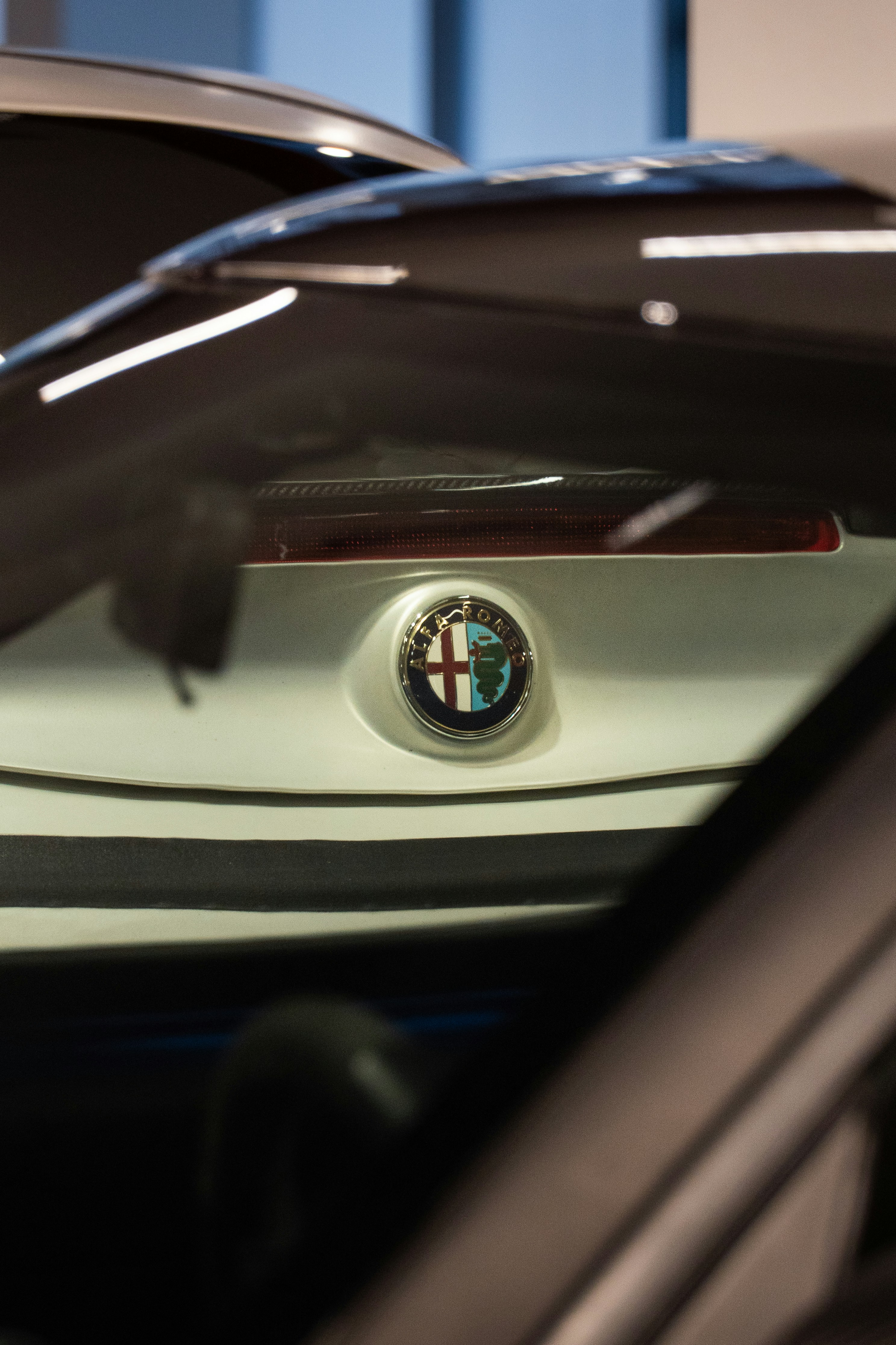 Rearview Reflections: Alfa Romeo Crest Framed in Car Window