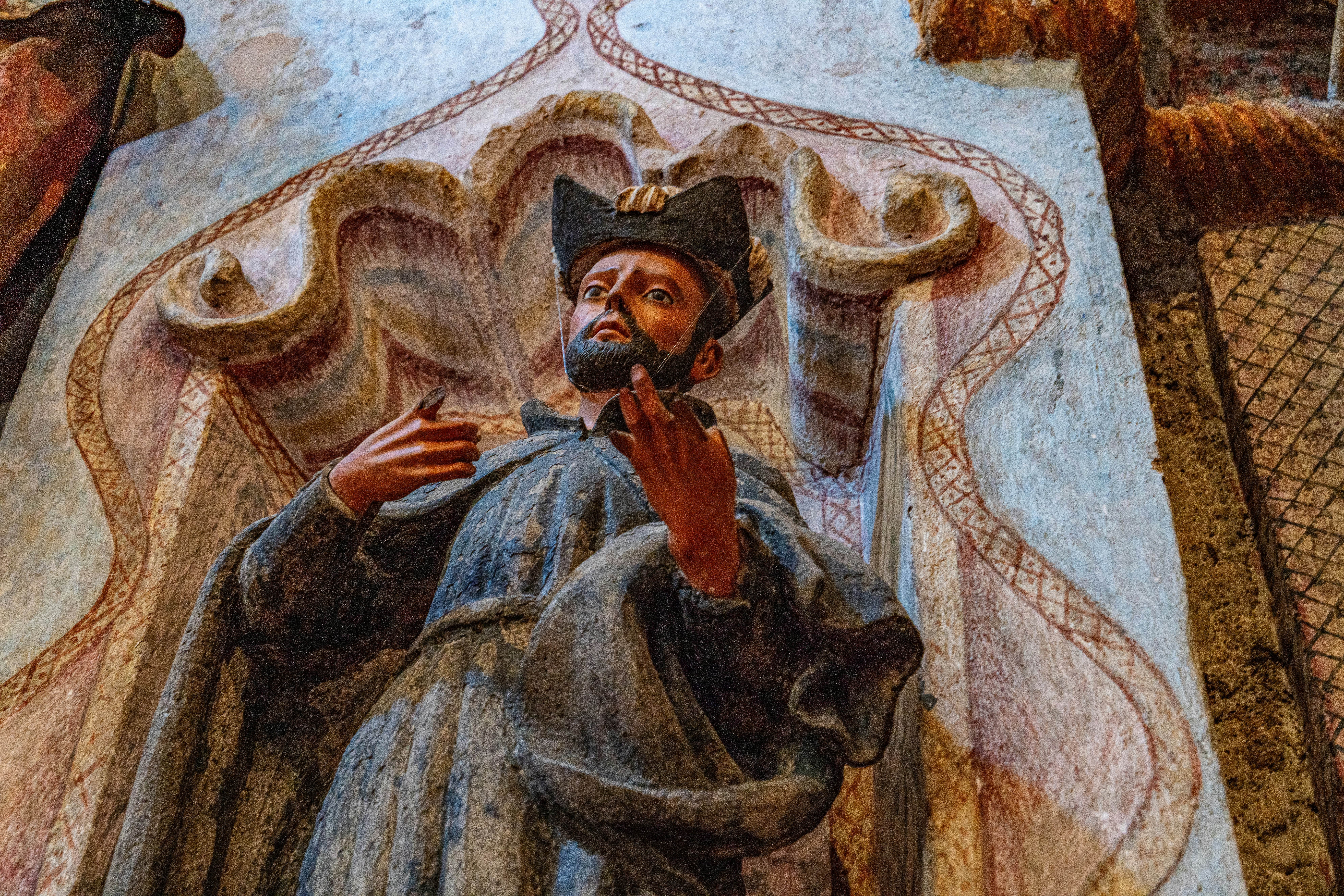Stone Saint: A Weathered Portrait in a Carved Fresco