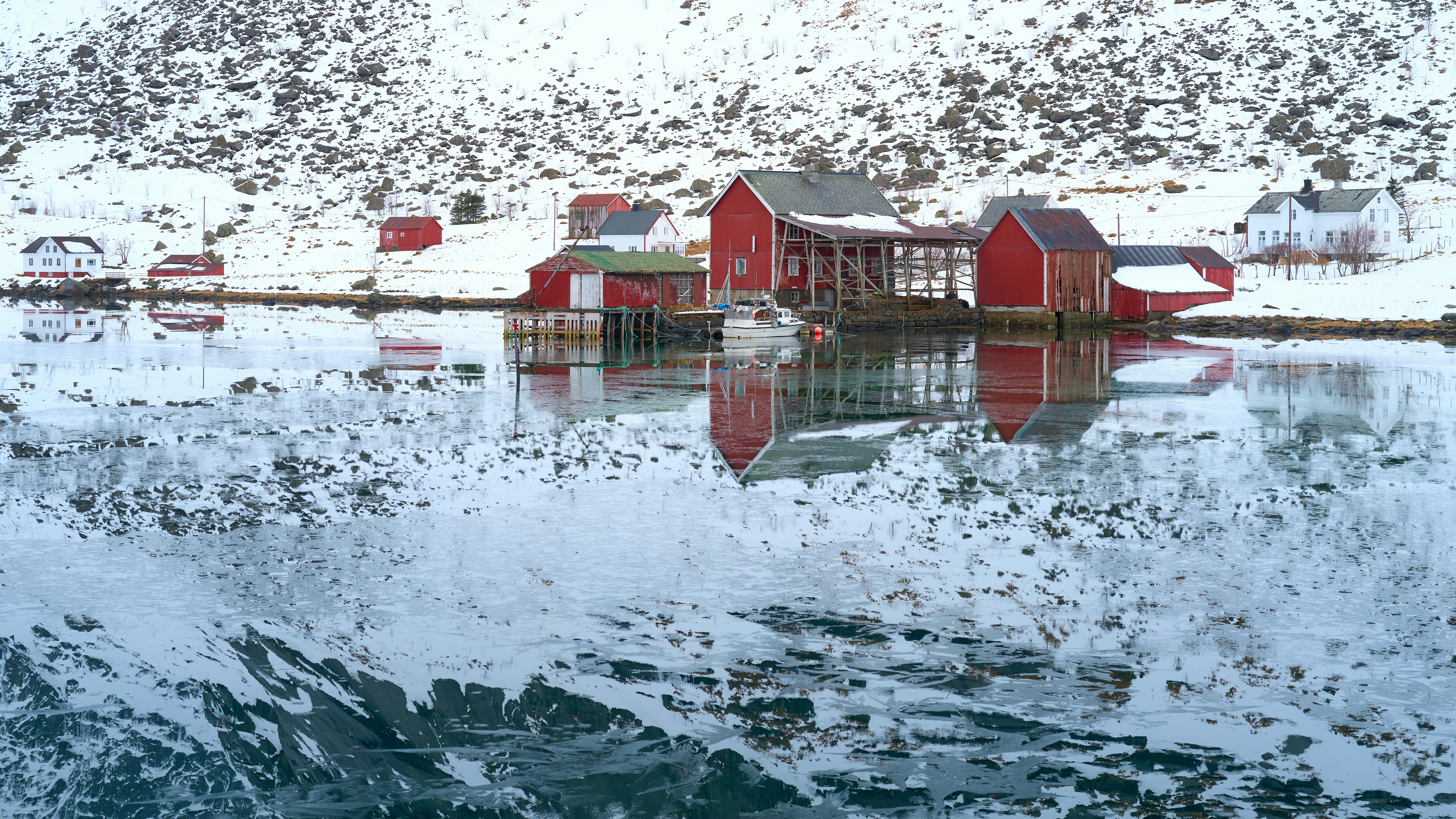 Red Boathouse Row Reflects on Icy Waters
