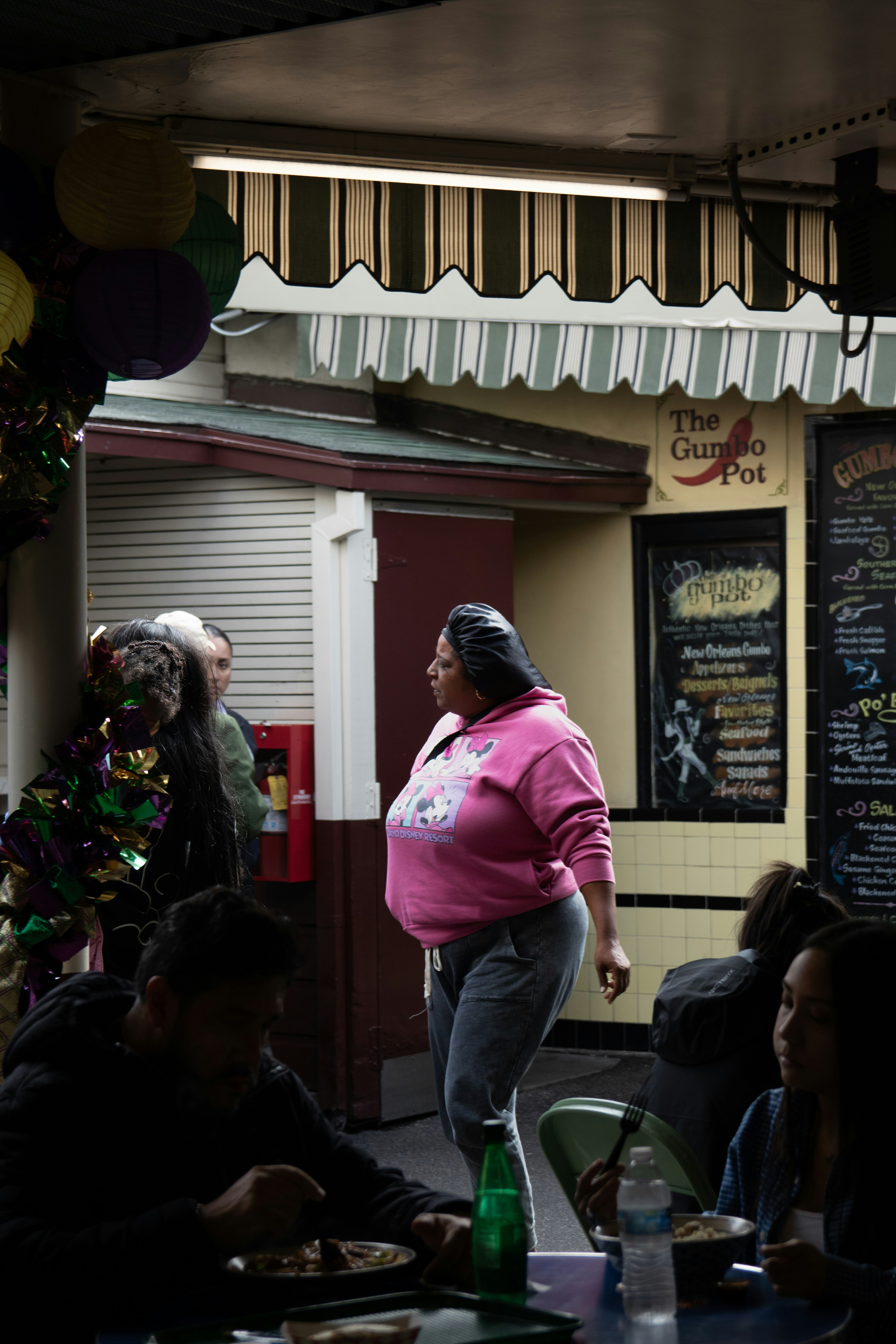 Pink hoodie in a bustling market cafe scene