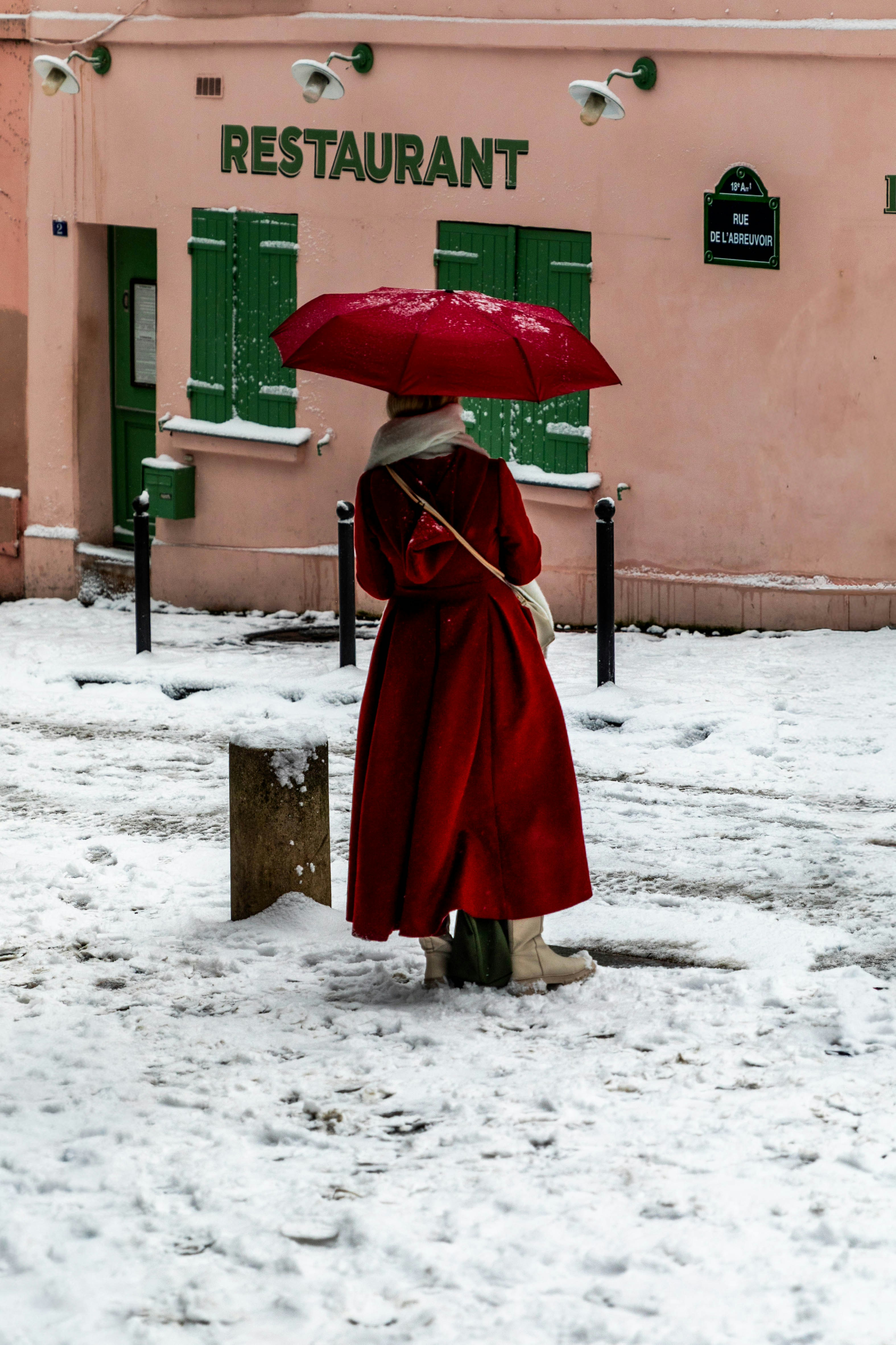 Redcoat in the Snow: A Quiet Moment Outside a Parisian Restaurant