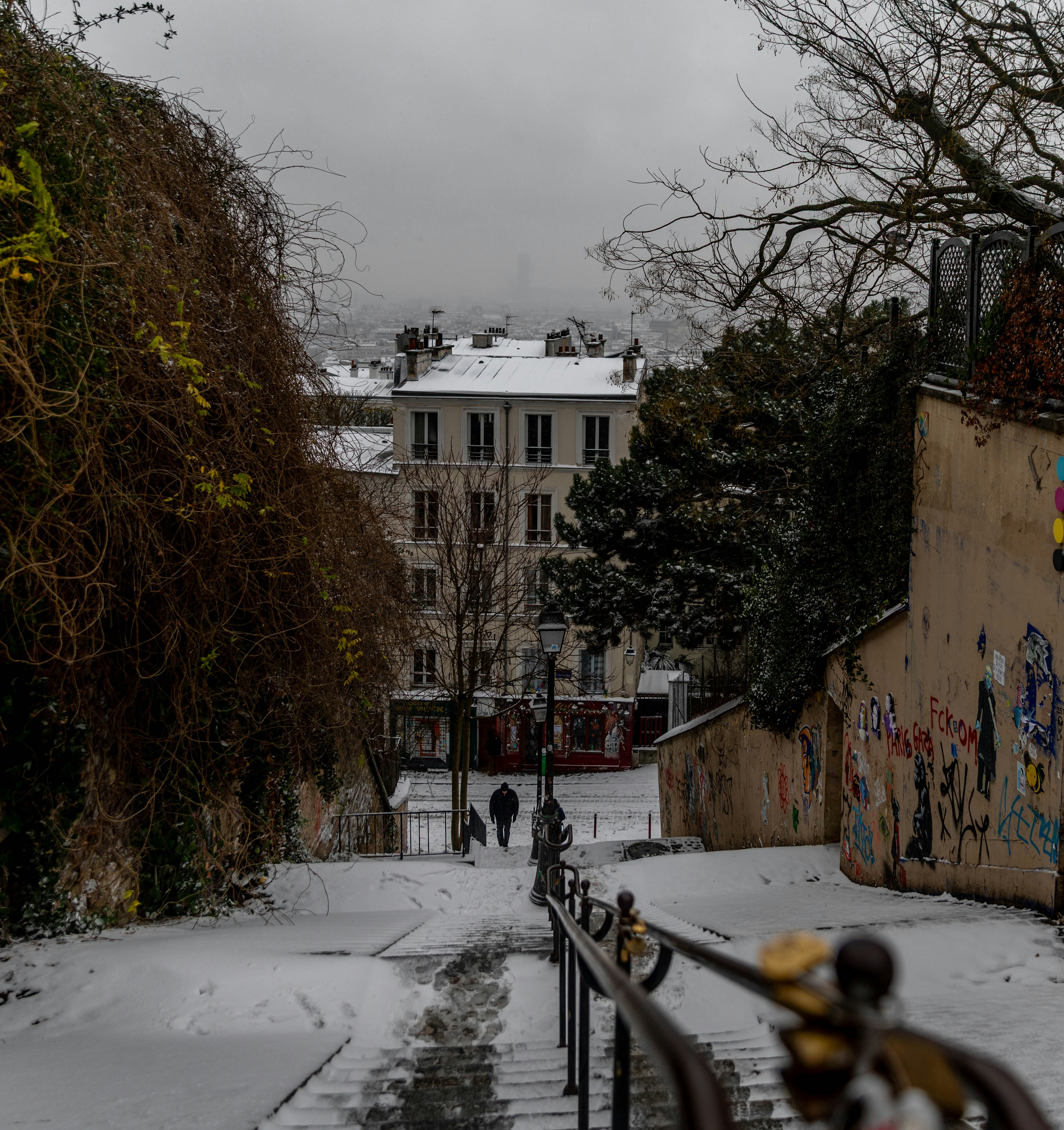 Snowy descent toward the city: a Parisian stairwell funneling light to a distant street