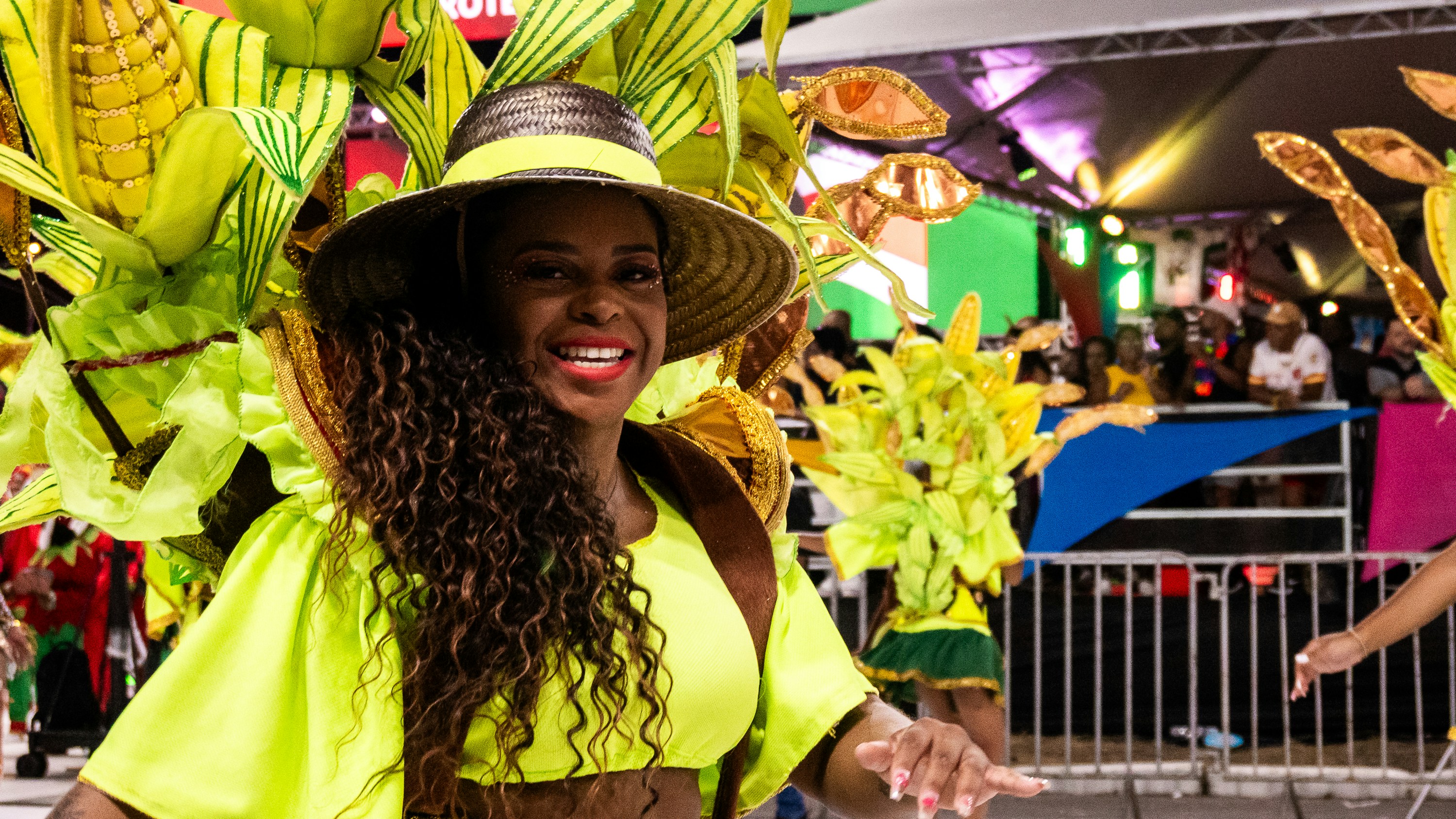 Carnival Smile: Bright dress and straw hat amid vibrant parade