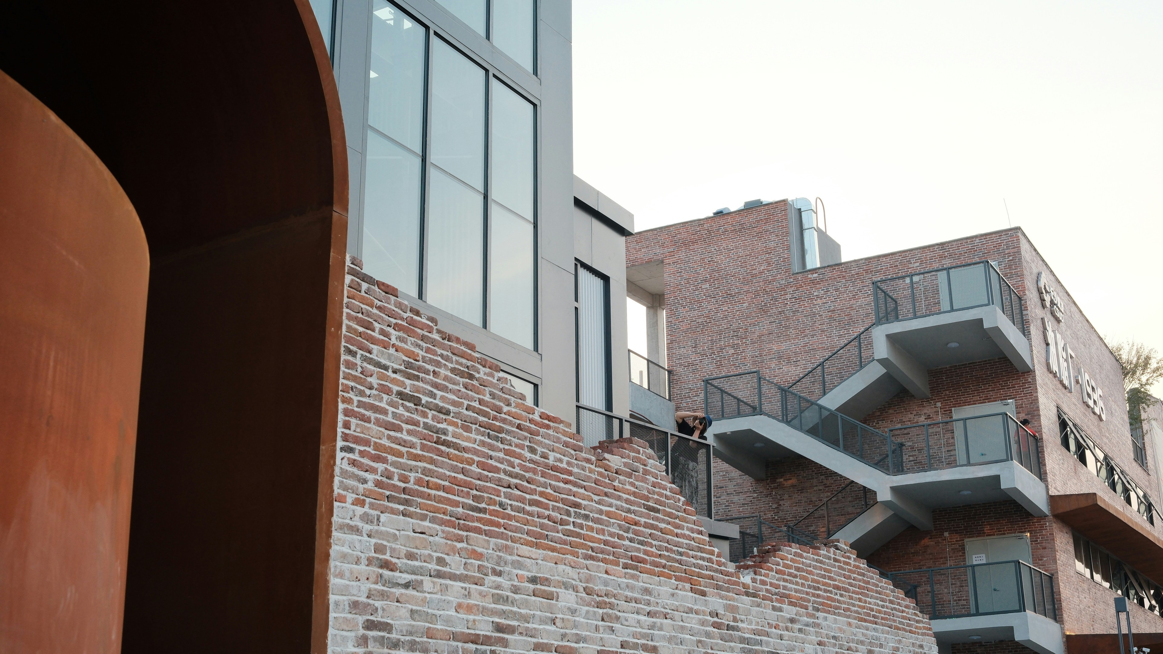 Brick and Glass Ascent: An Urban Facade with Industrial Staircase