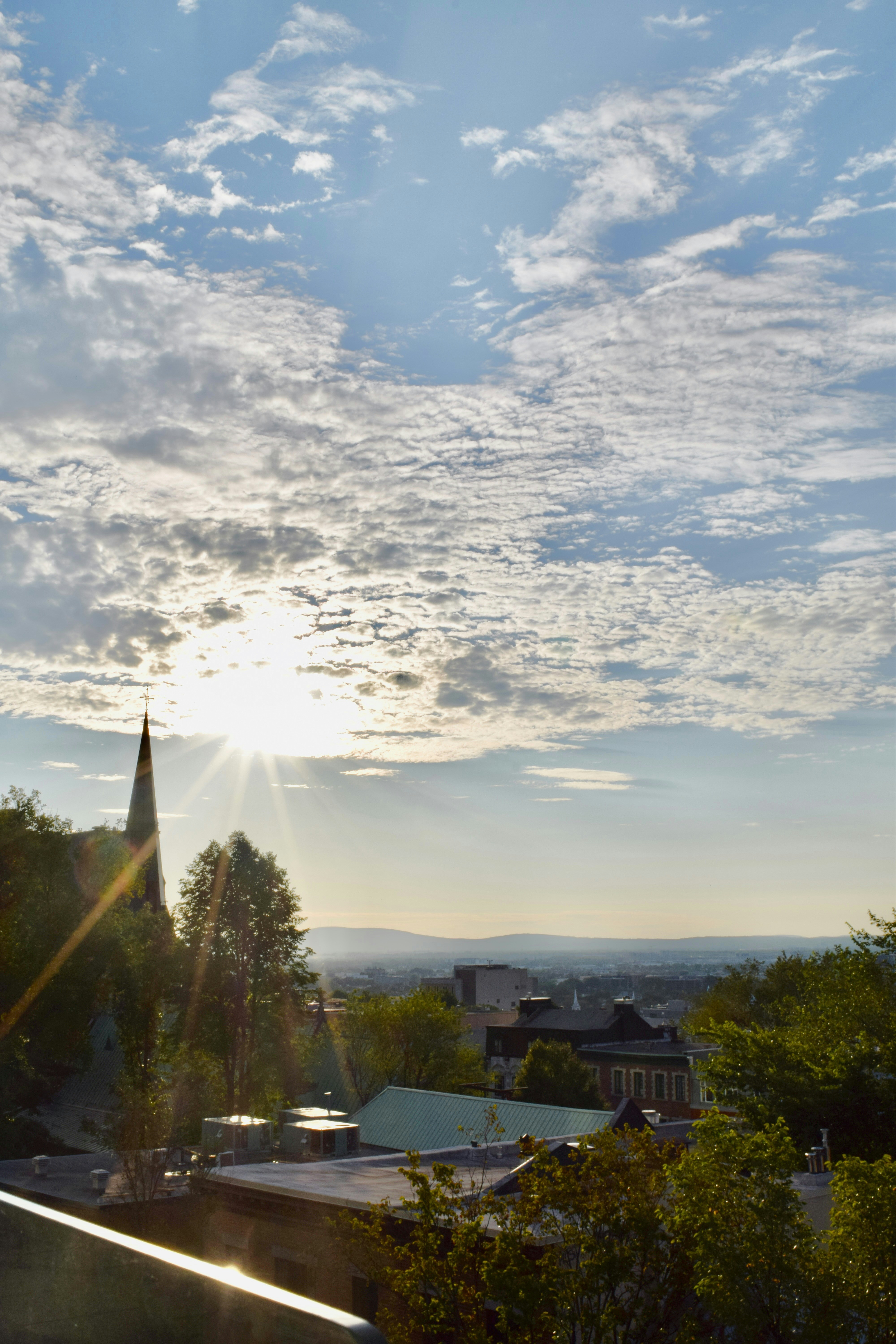 Sunrise over the town: a quiet rooftop vista with sun rays breaking through clouds