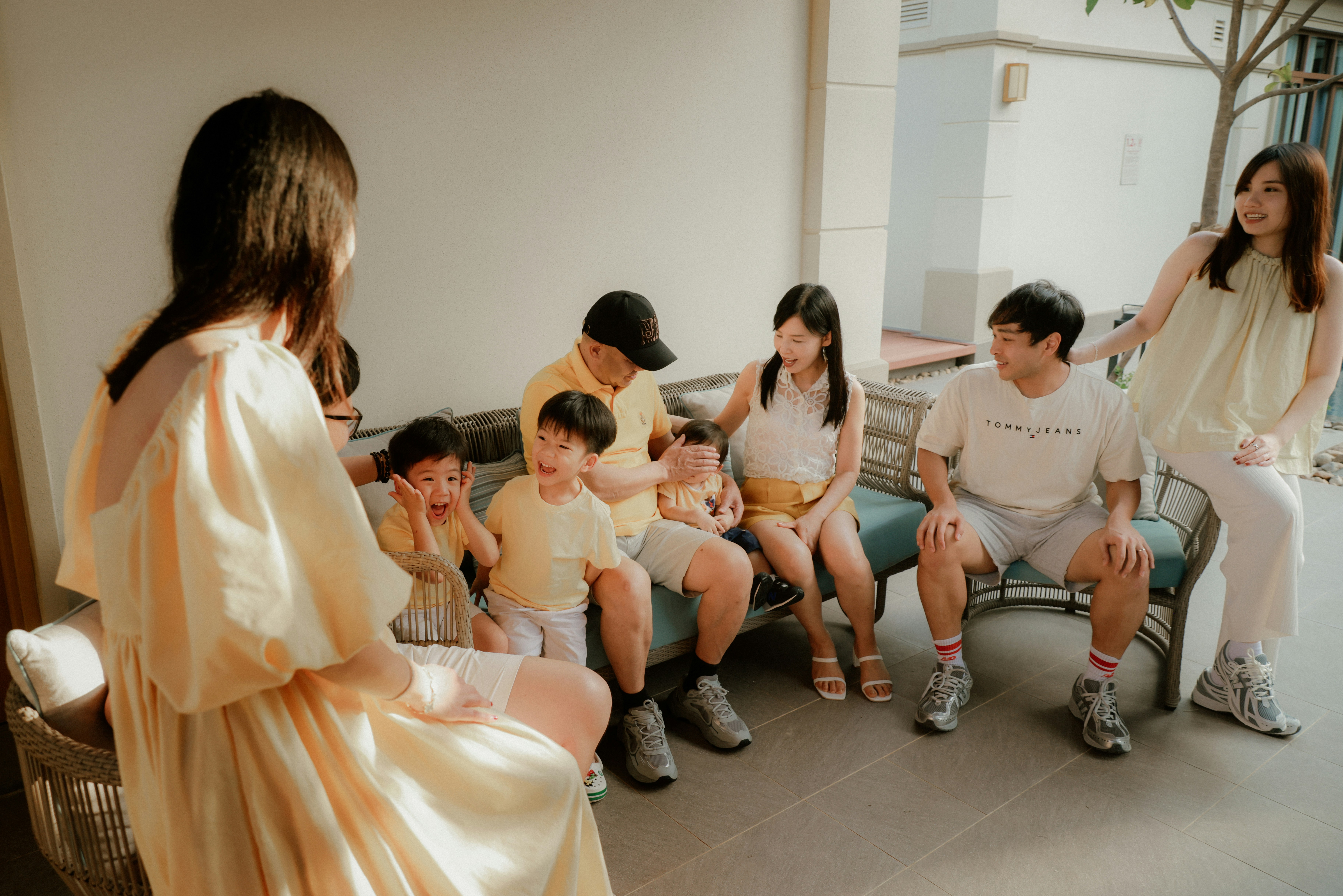 A Warm Circle: Adults and Children Gather on a Cushioned Porch