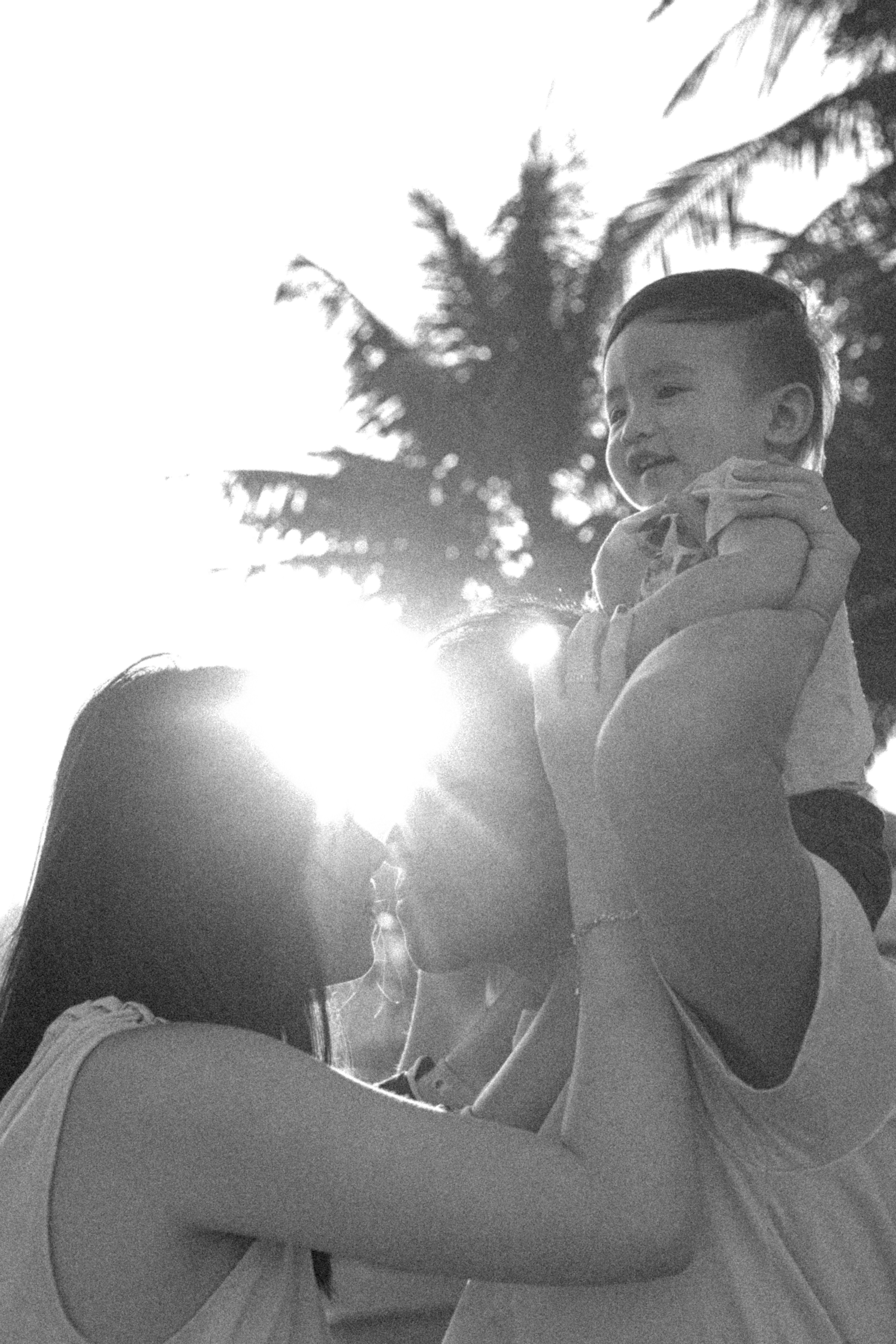 Sunlit embrace: a tender moment between a mother and child above the horizon