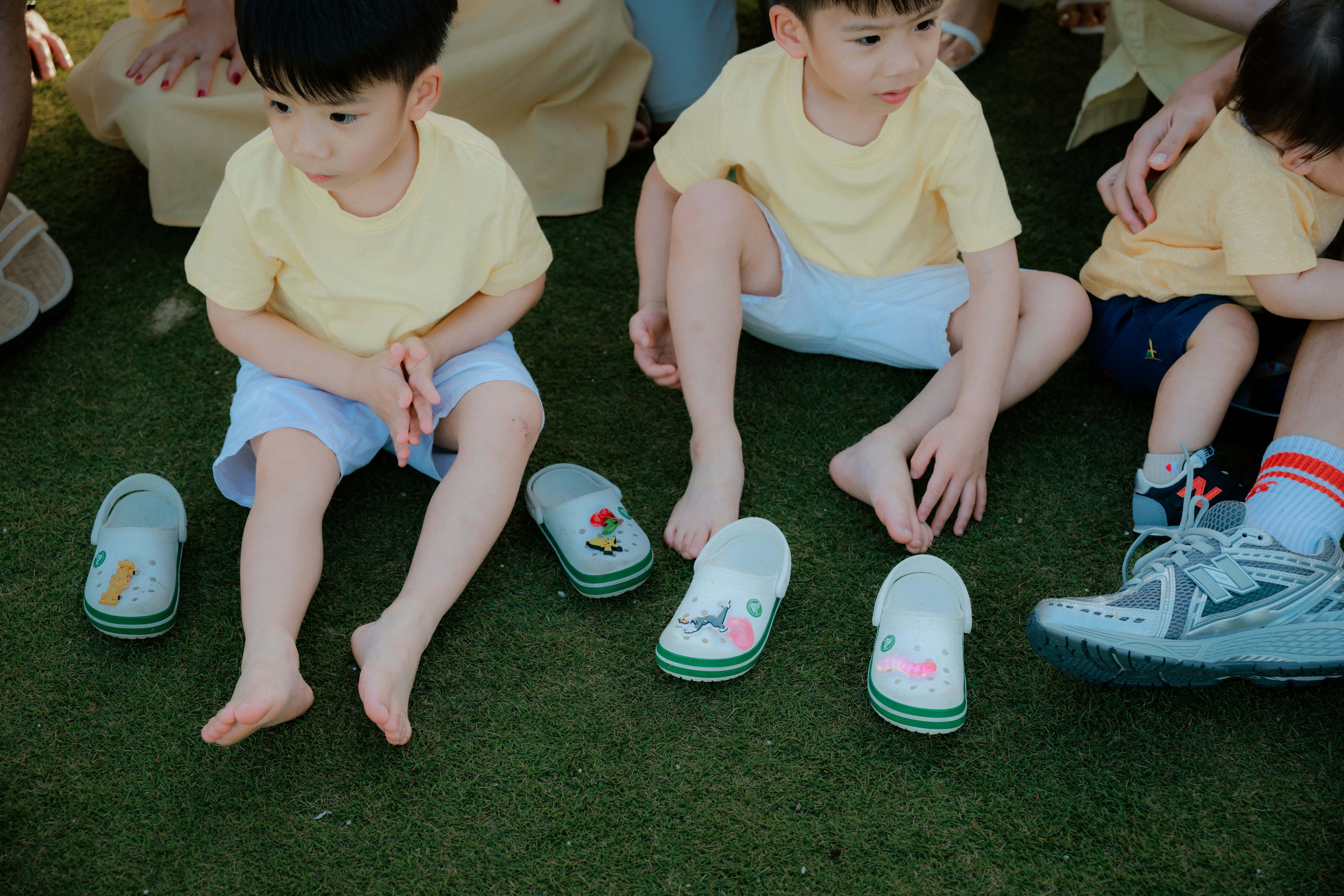 Kids’ Quiet Moment: Colorful Slippers and Bare Feet on Soft Grass