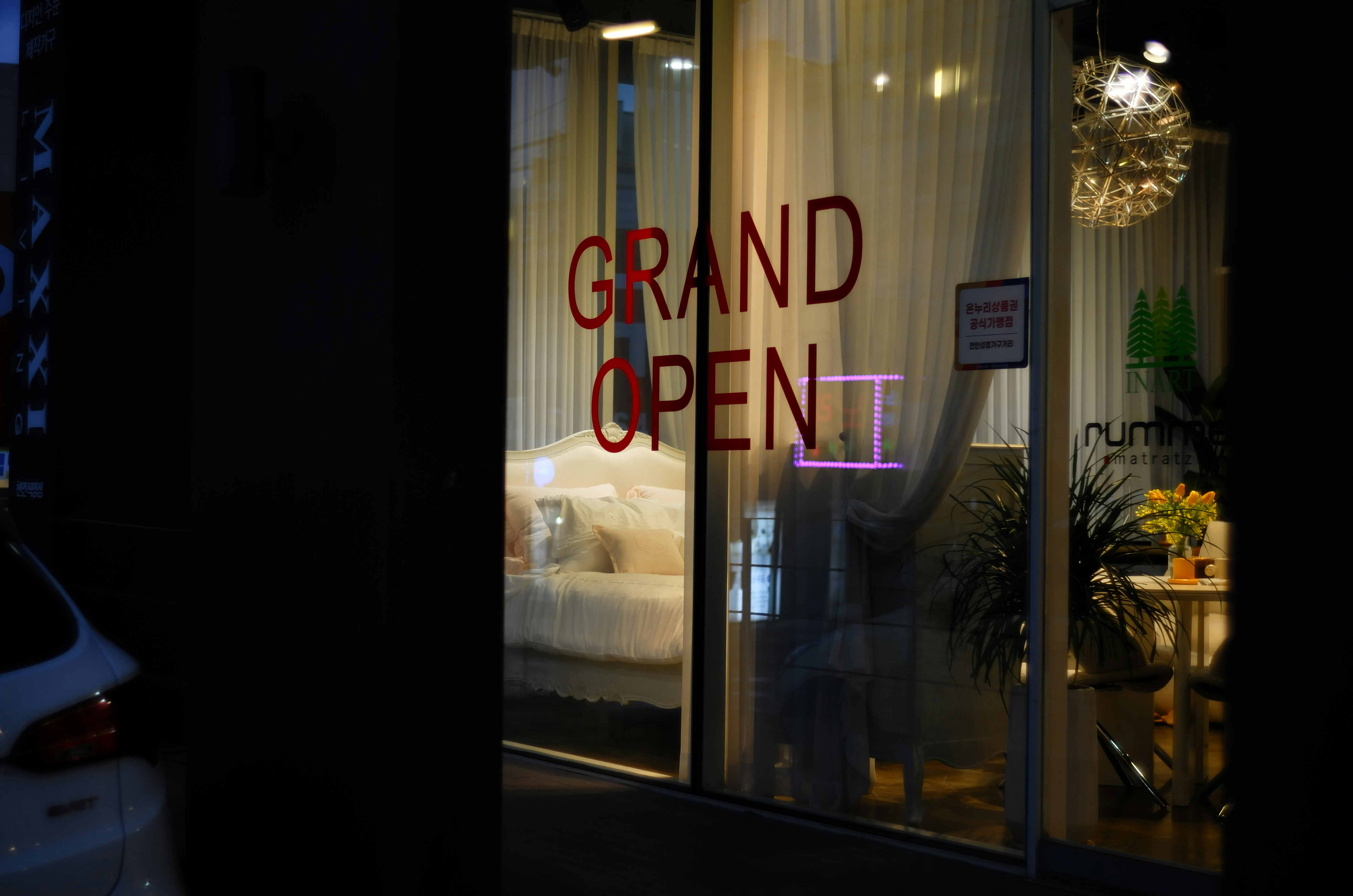 Grand open sign in a lit storefront window