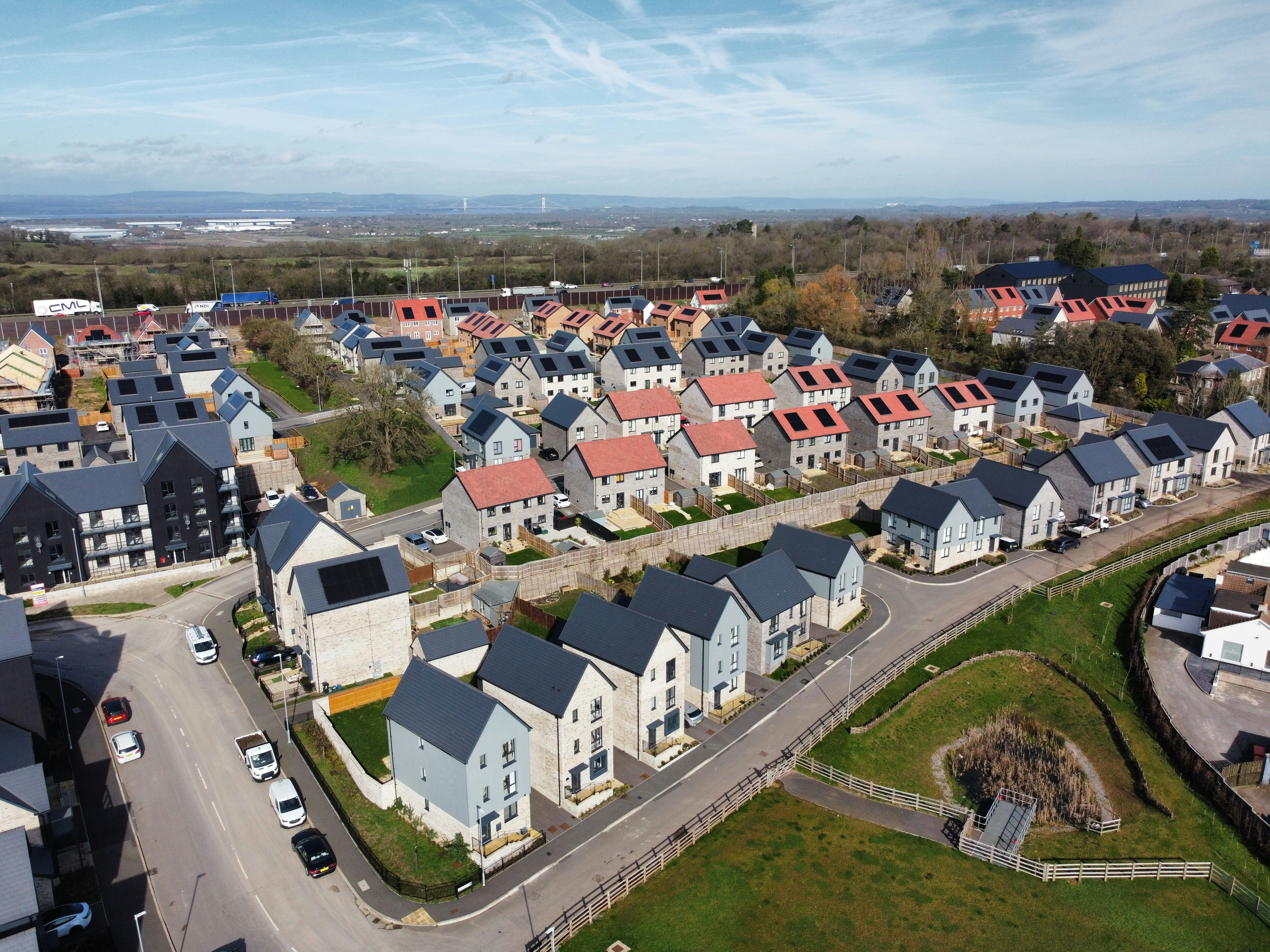 Aerial grid of pastel-hued townhomes under a broad coastal horizon