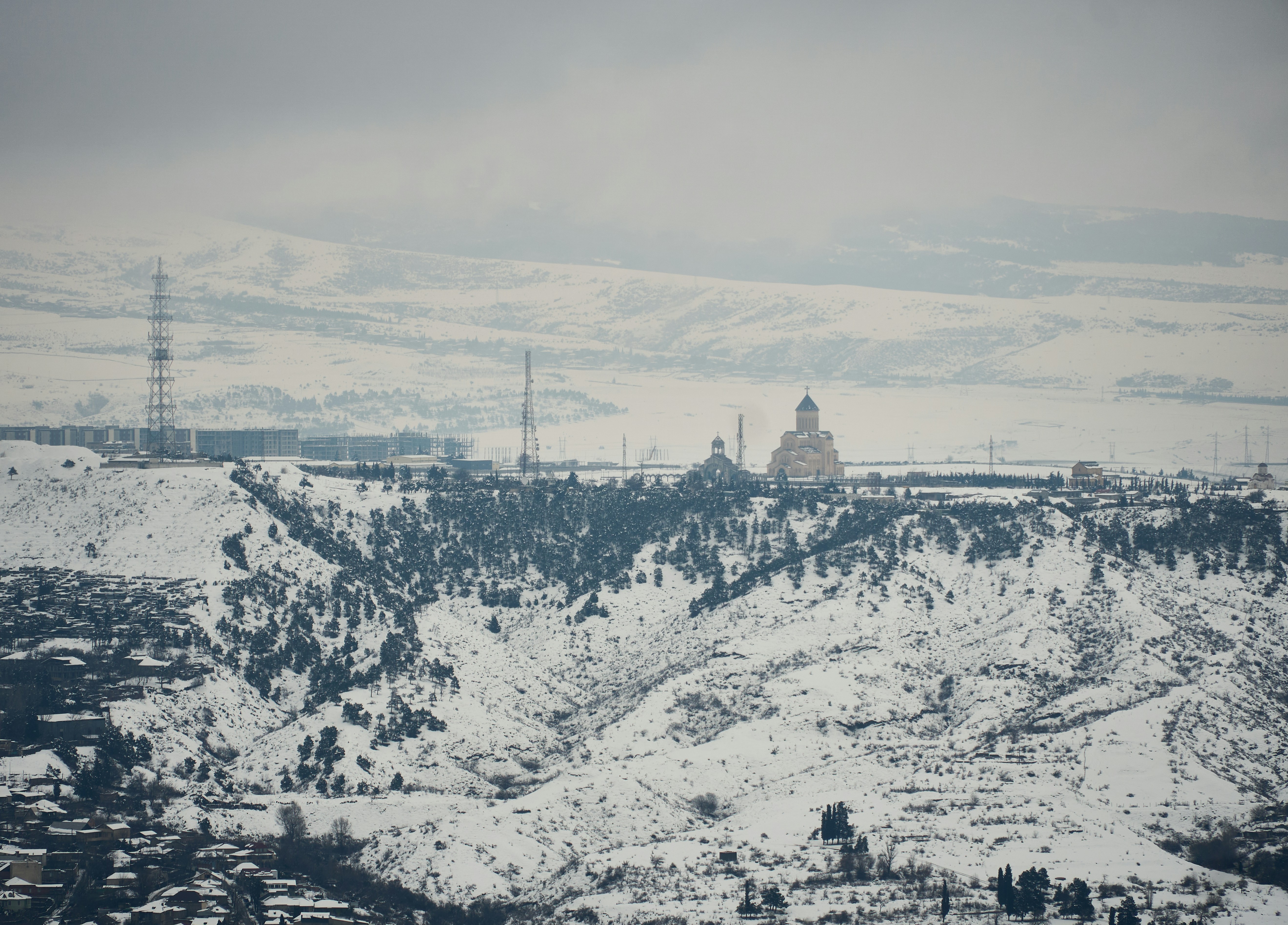 Winter Horizon: Snow-Covered Hills and a Distant Dome