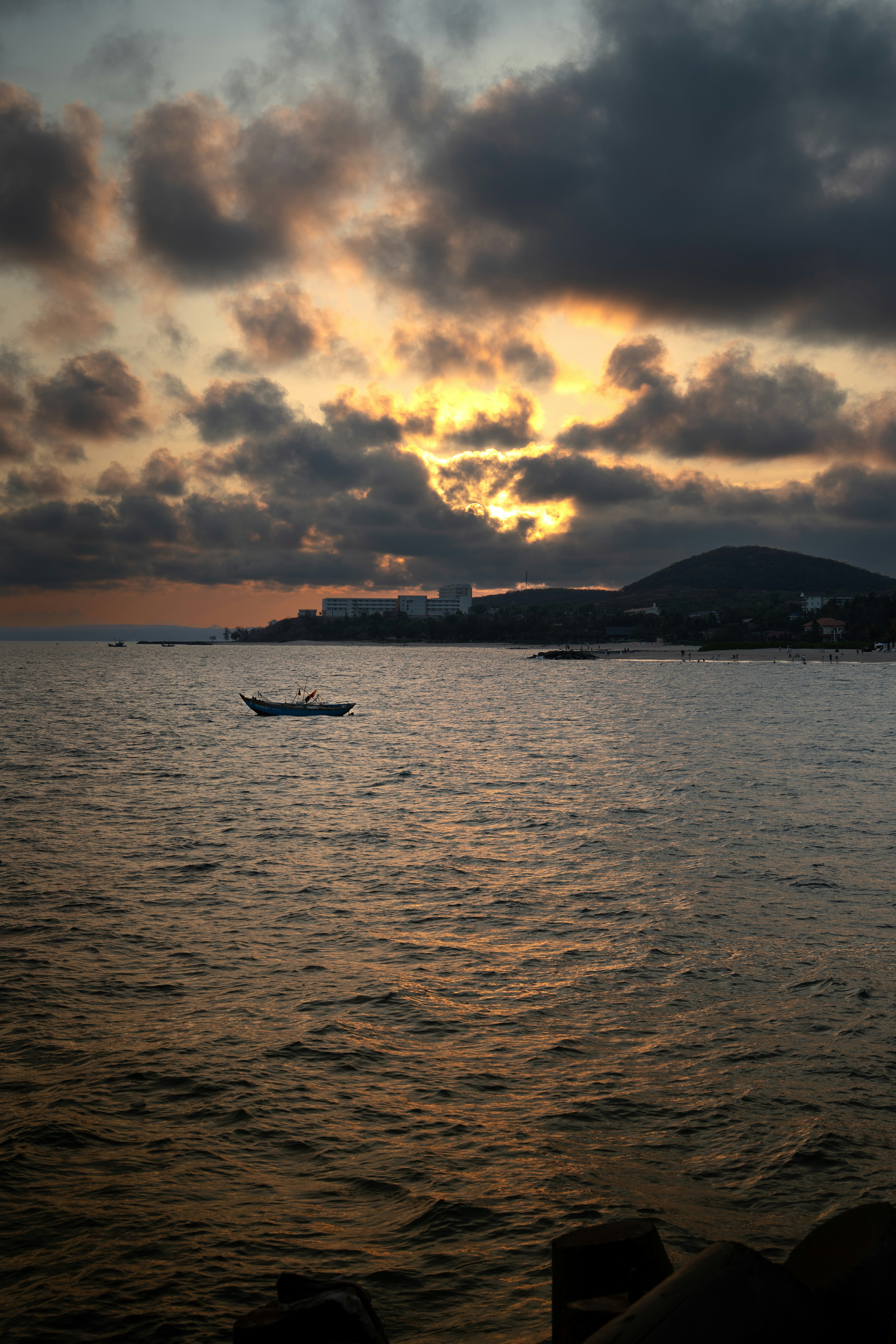 Sunset Over Quiet Bay with Distant Hill and Small Boat