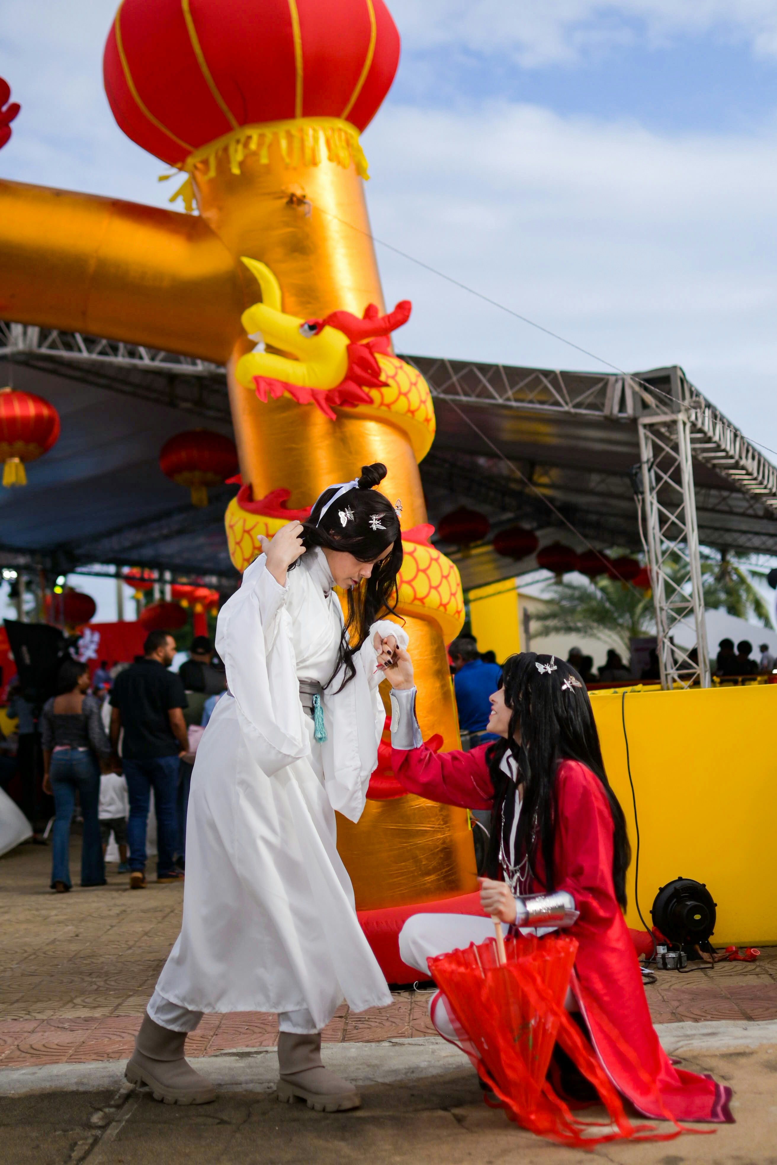 Masked reunion under a dragon arch: cosplay moment at a festival