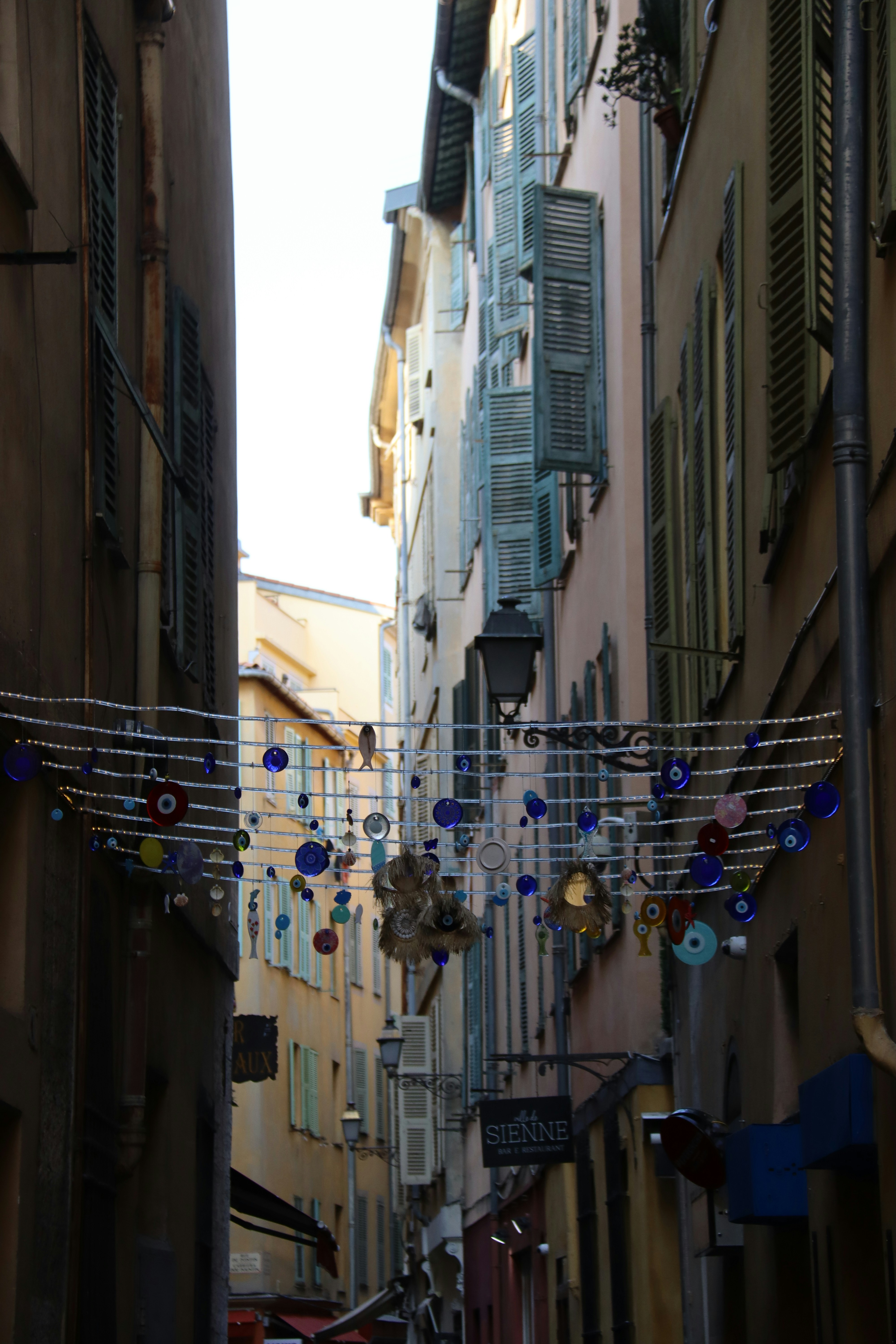Cafe string lights over a sunlit Venetian alley