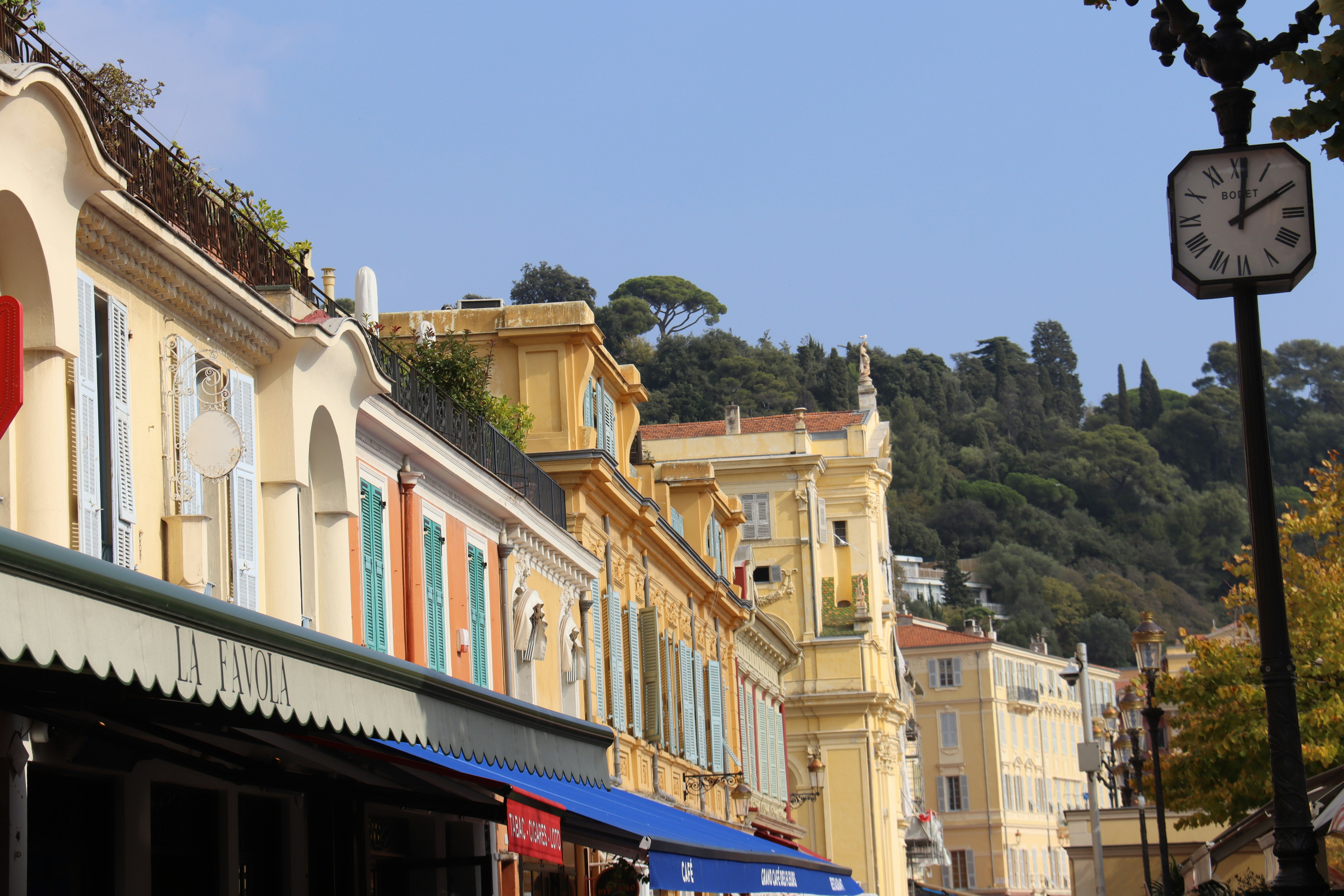 Clock Over Piazza: A Sunlit Street of Pastel Facades