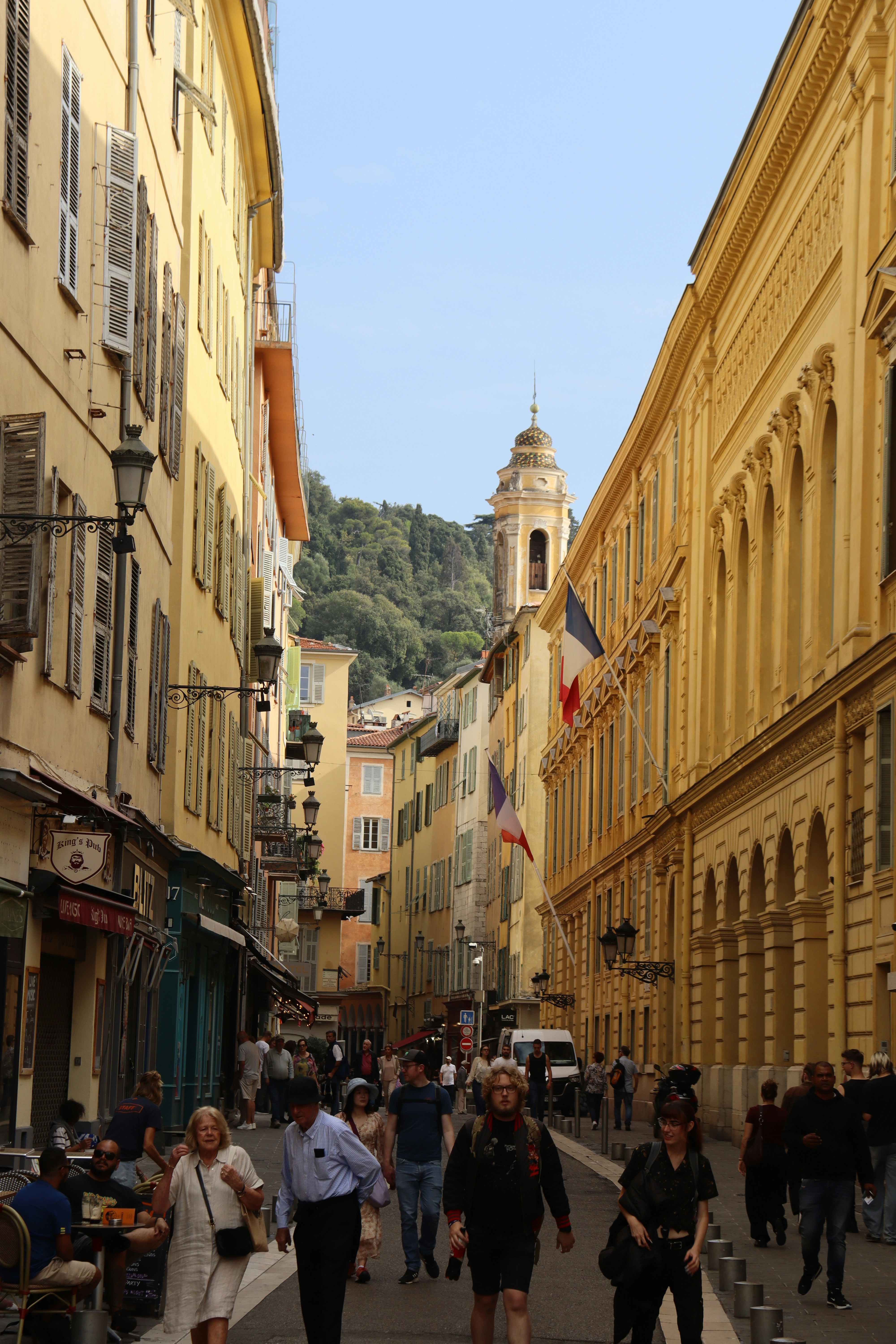 Sunlit Rue in Old Town with Clock Tower Spotlight