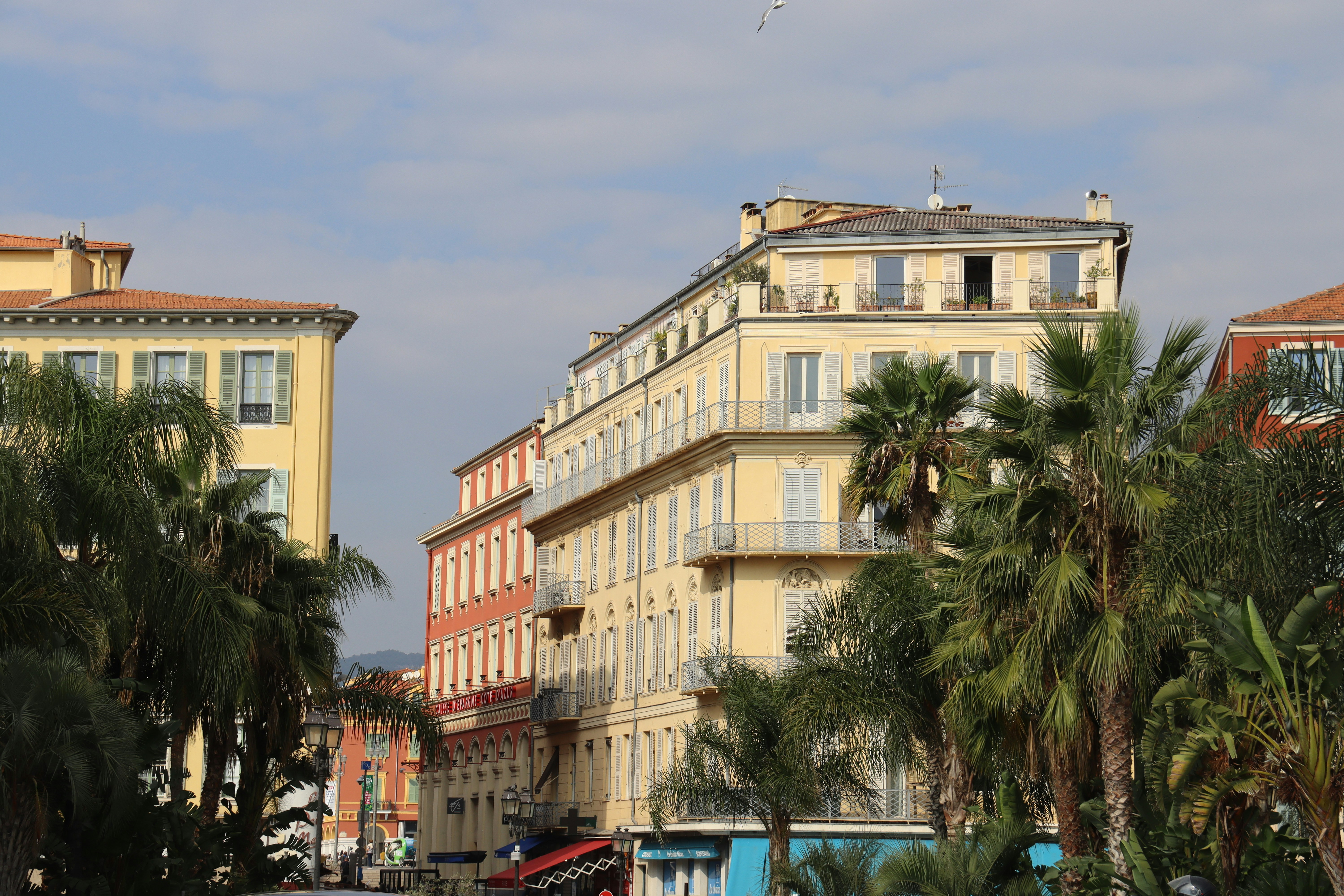 Sunlit Rue de la Mer with Pale-Yellow Facades and Tropical Palms
