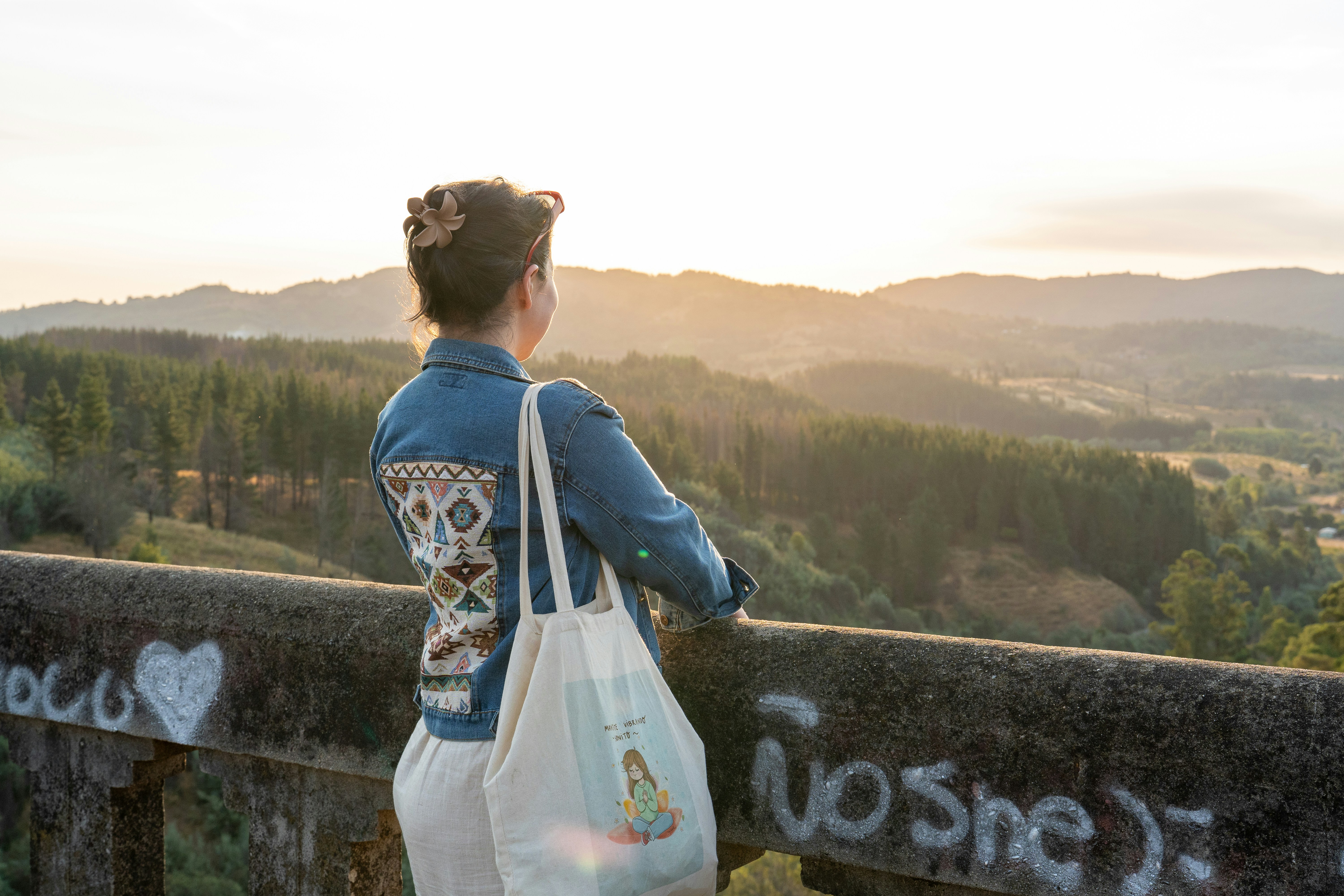 Sunlit overlook: a denim-clad silhouette at the edge