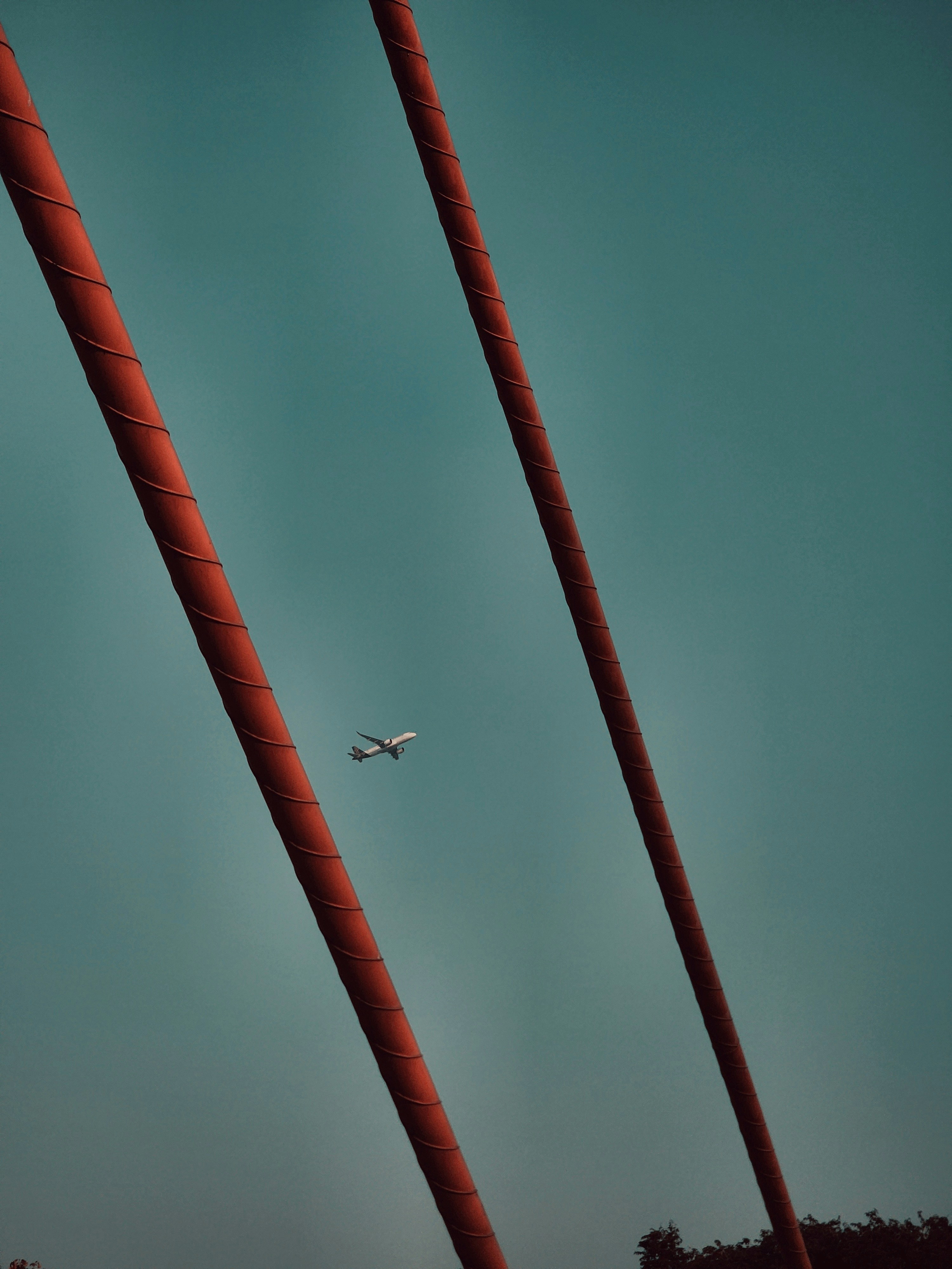 Aircraft between Crimson Cables: A Quiet Moment in a Wide Sky