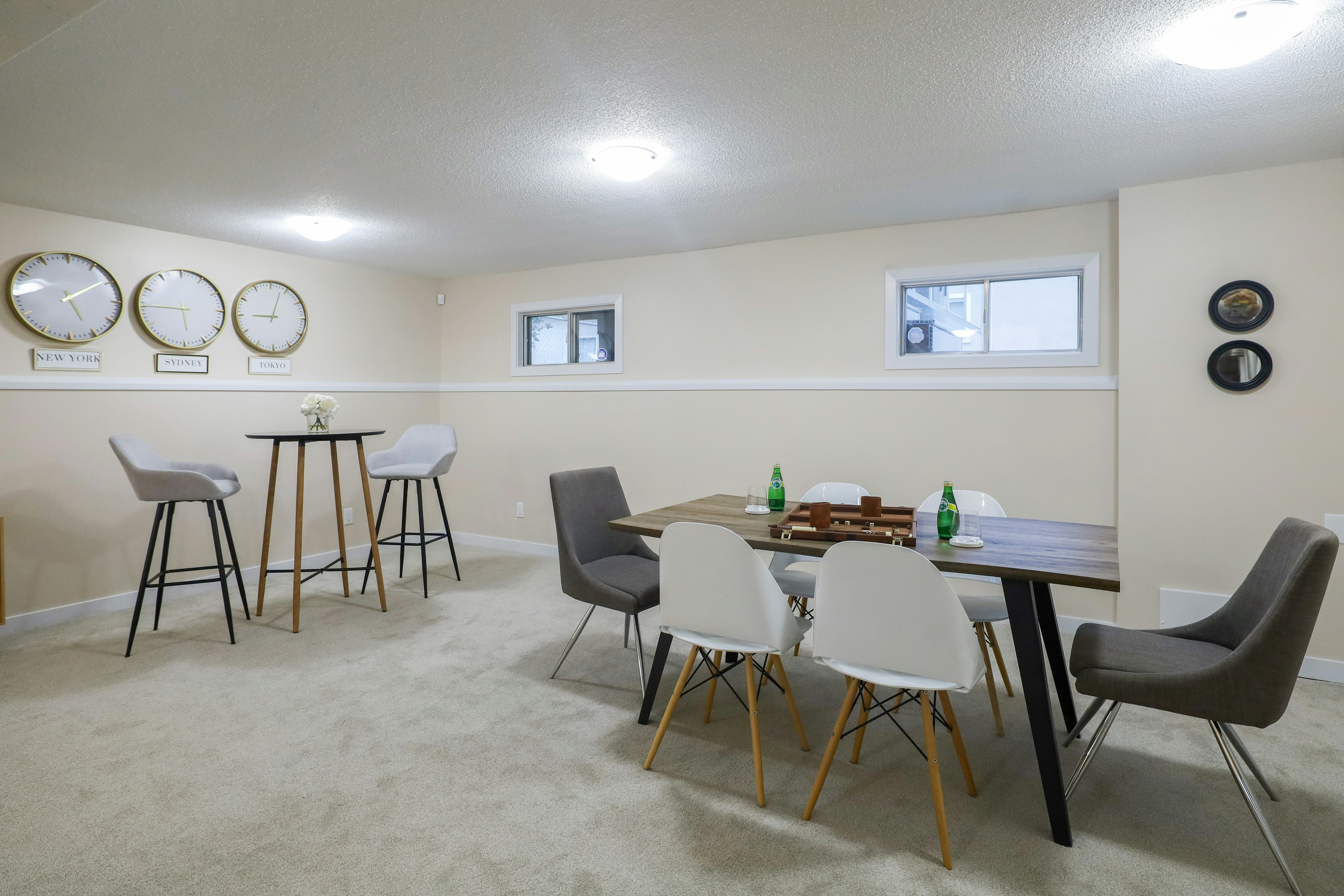 Neutral Meeting space with a mid-century dining table and wall clocks