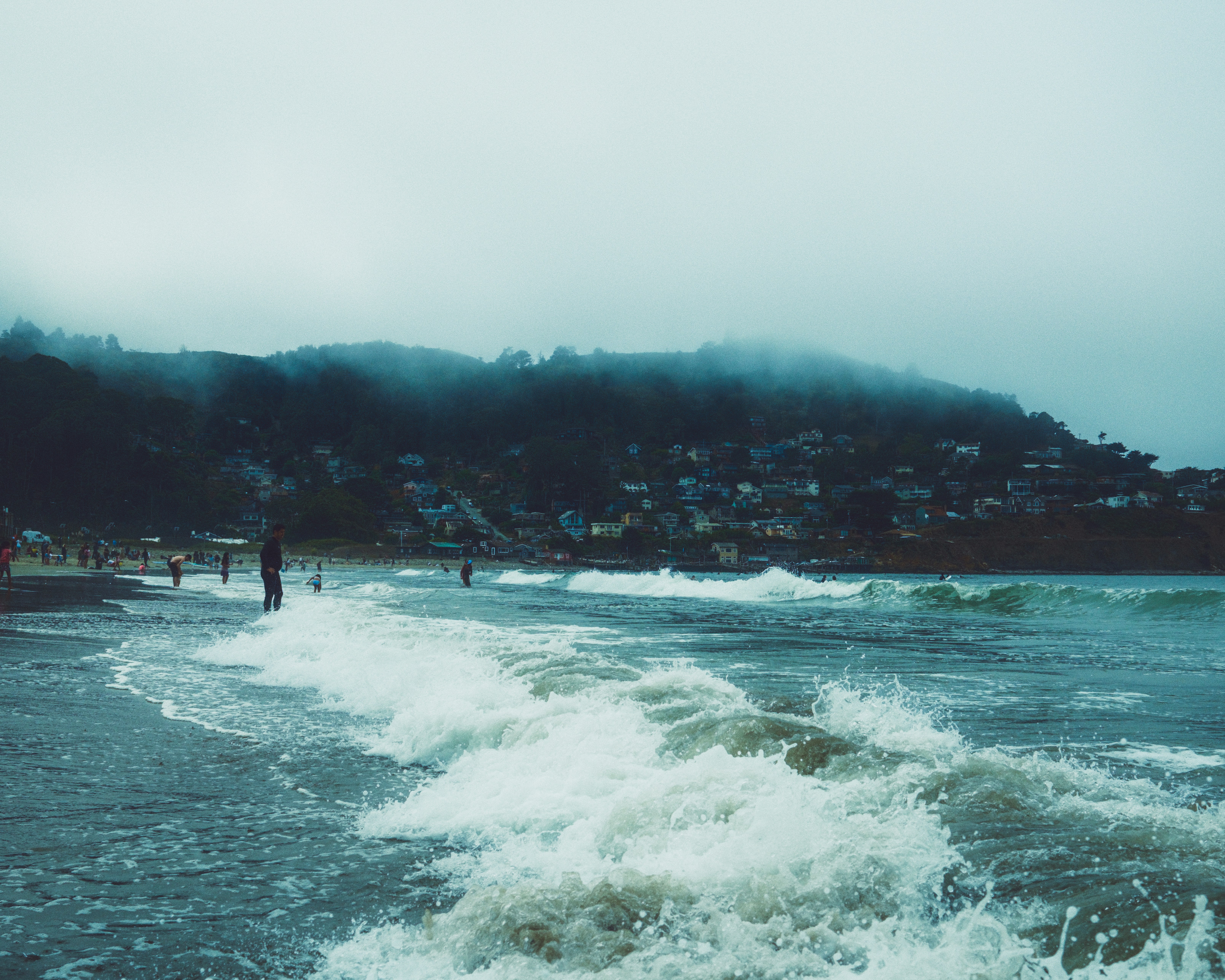 Coastal Line: Waves Reaching a Quiet Shore Under Misty Hills