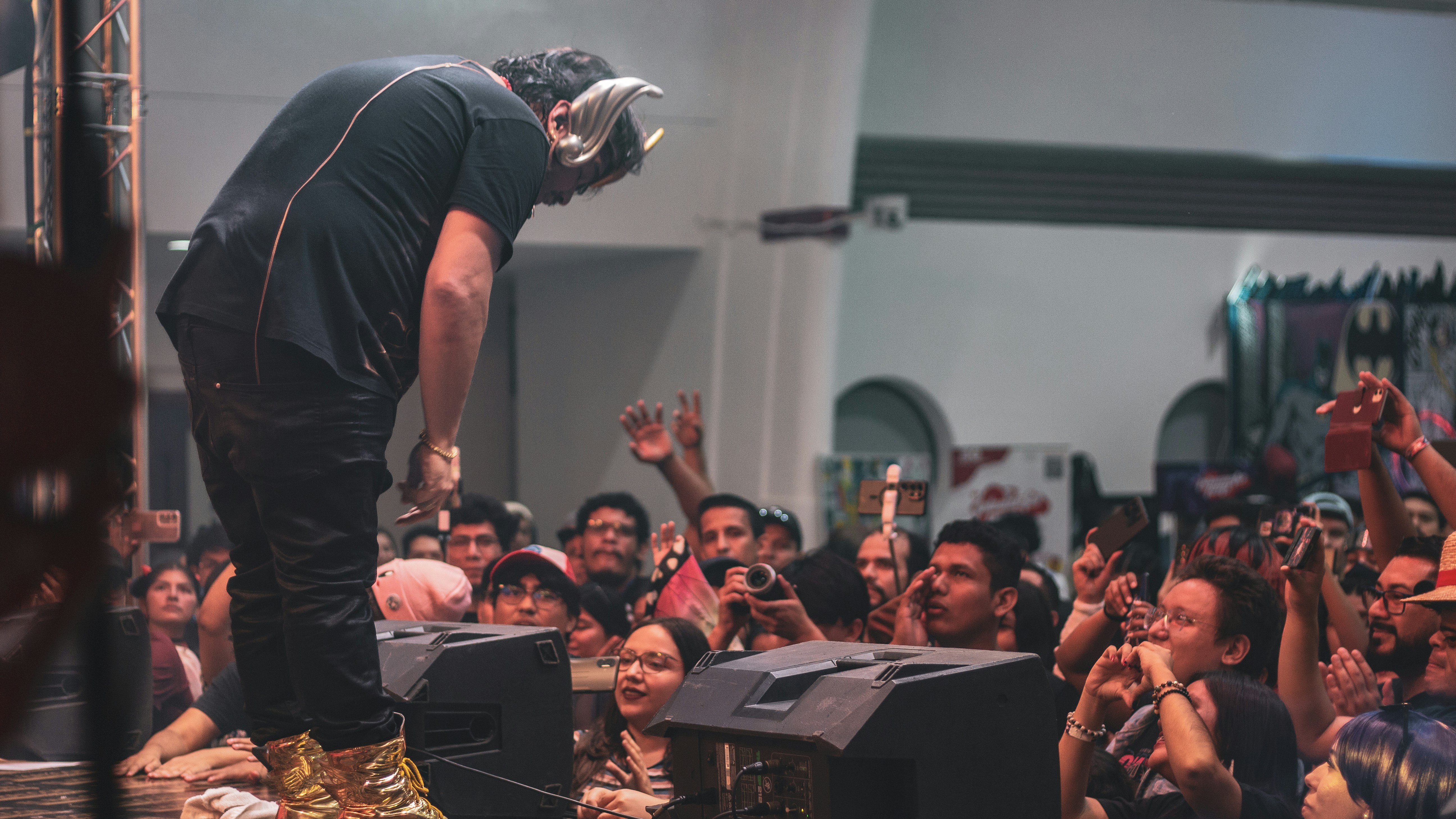 Crowd Surf: A masked performer bowed over a sea of eager fans