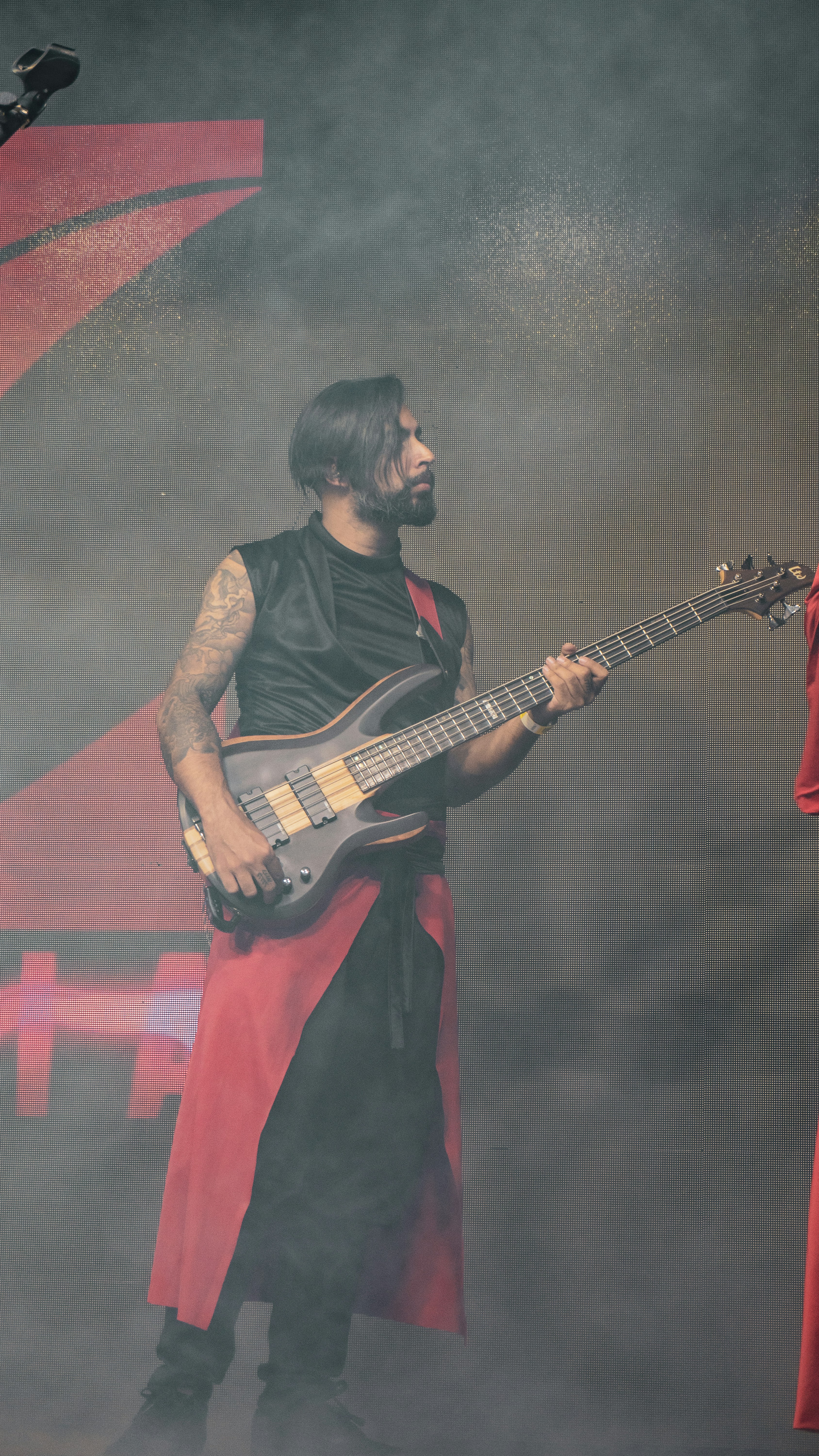 Basslines at Stage Left: A Guitarist in Red and Black