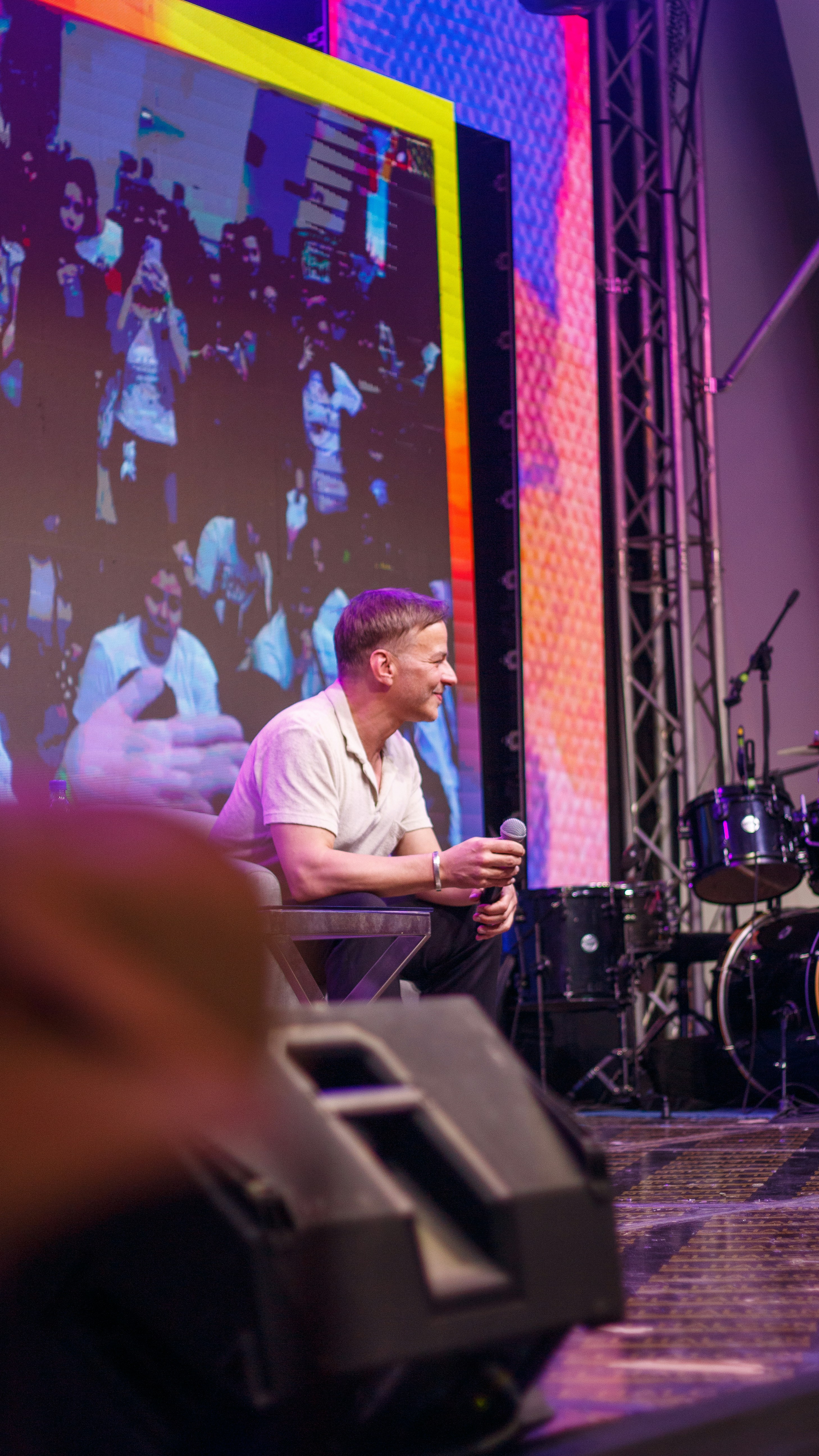 Stage Presence: The Speaker by the Neon Screen
