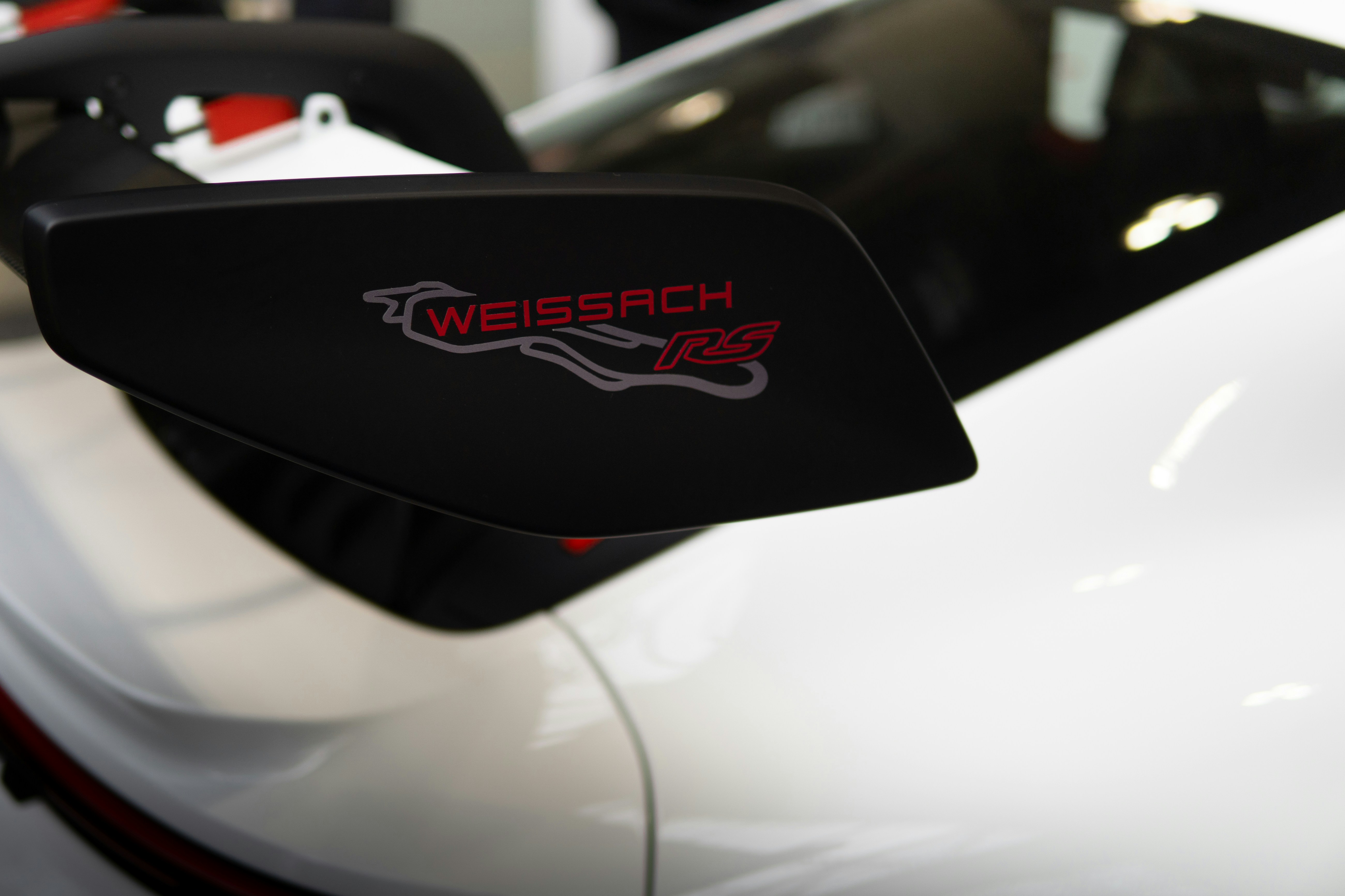 Weissach Wing: Precision glossy aero emblem on a white sports body