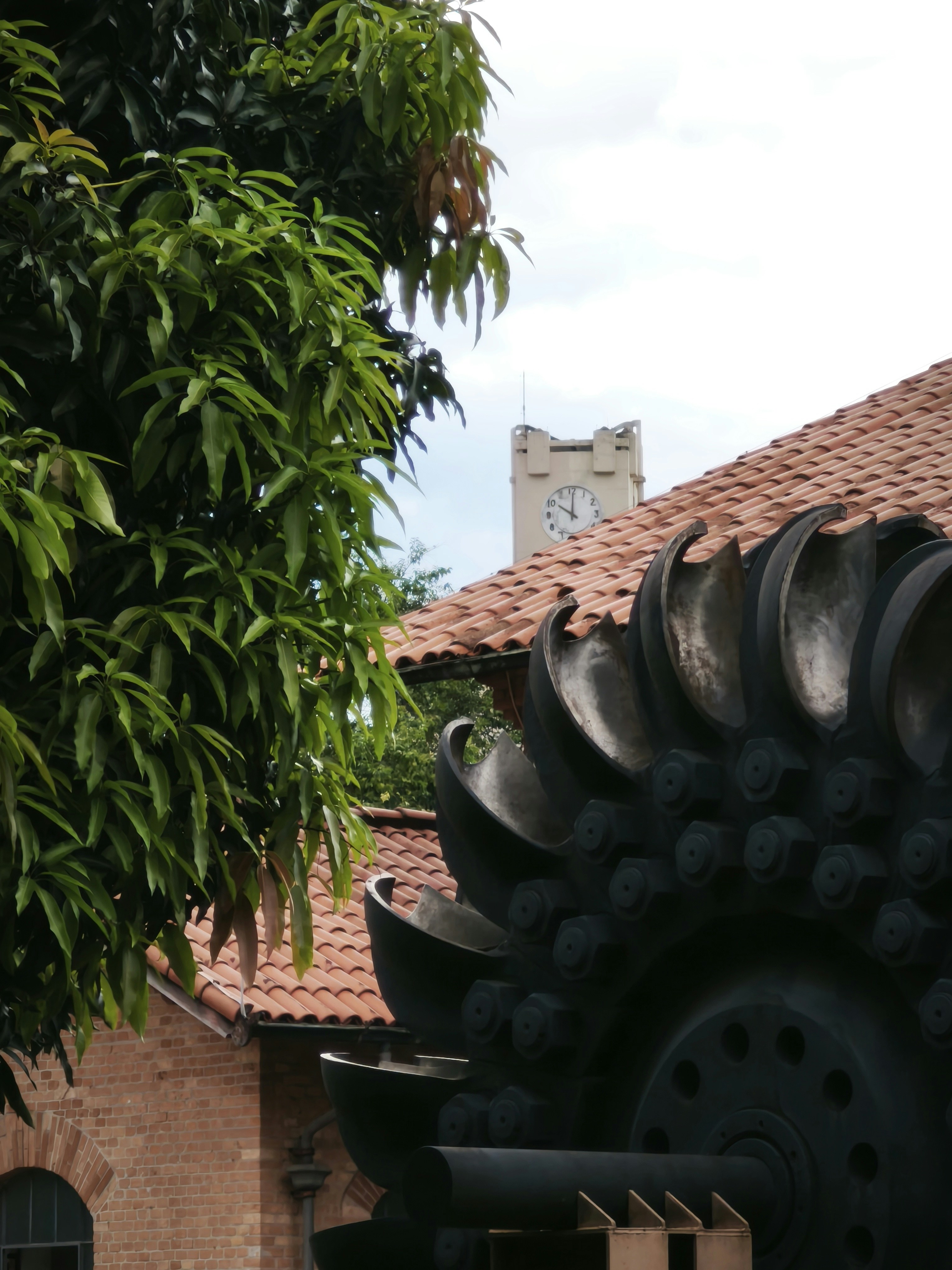 Large turbine wheel with building and clock tower background