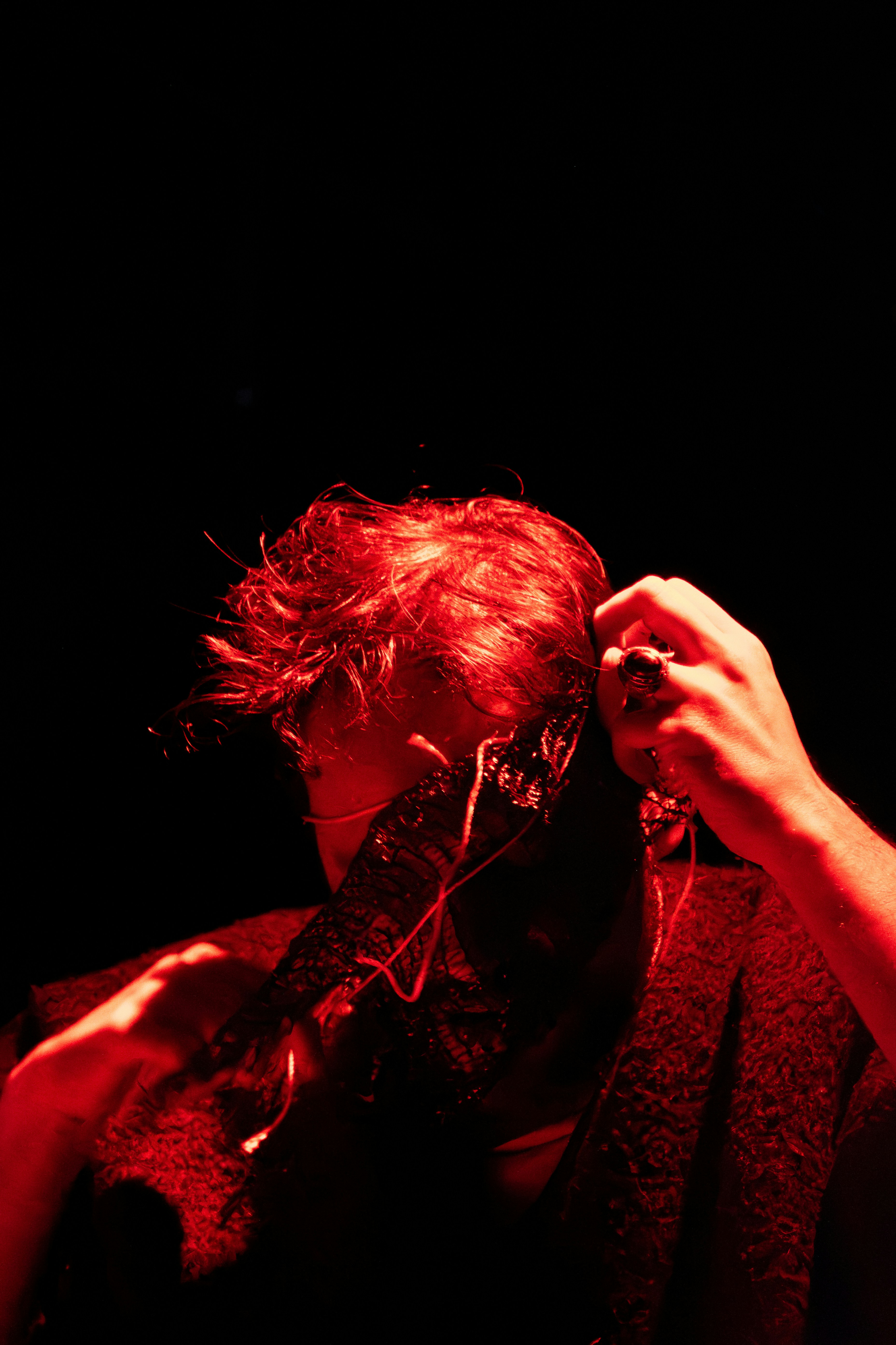 Crimson Spotlight: A Masked Moment in Red Light
