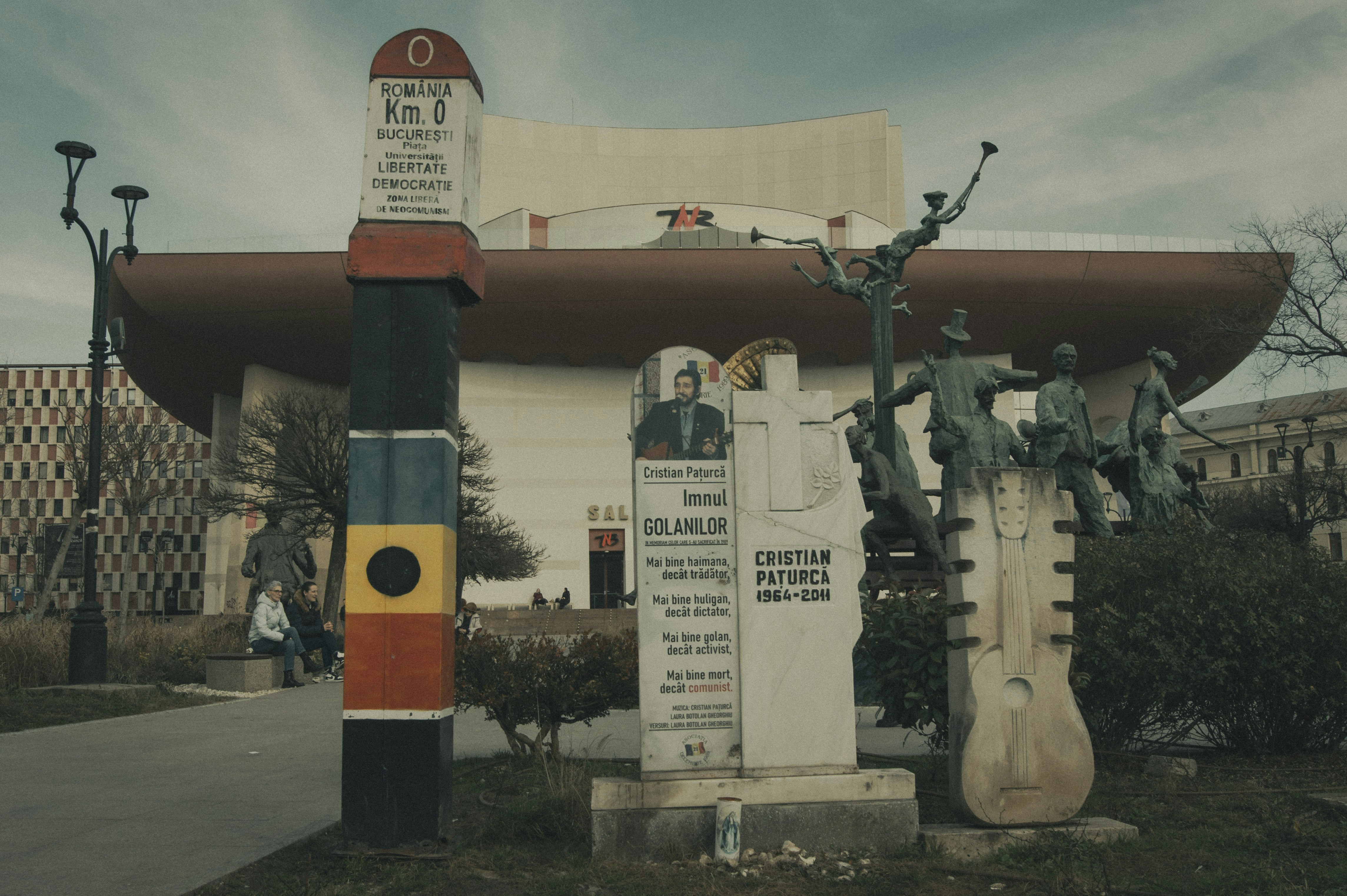 Monumental Ensemble: A Retro Square Framed by Sculpted Figures and a Towering Column