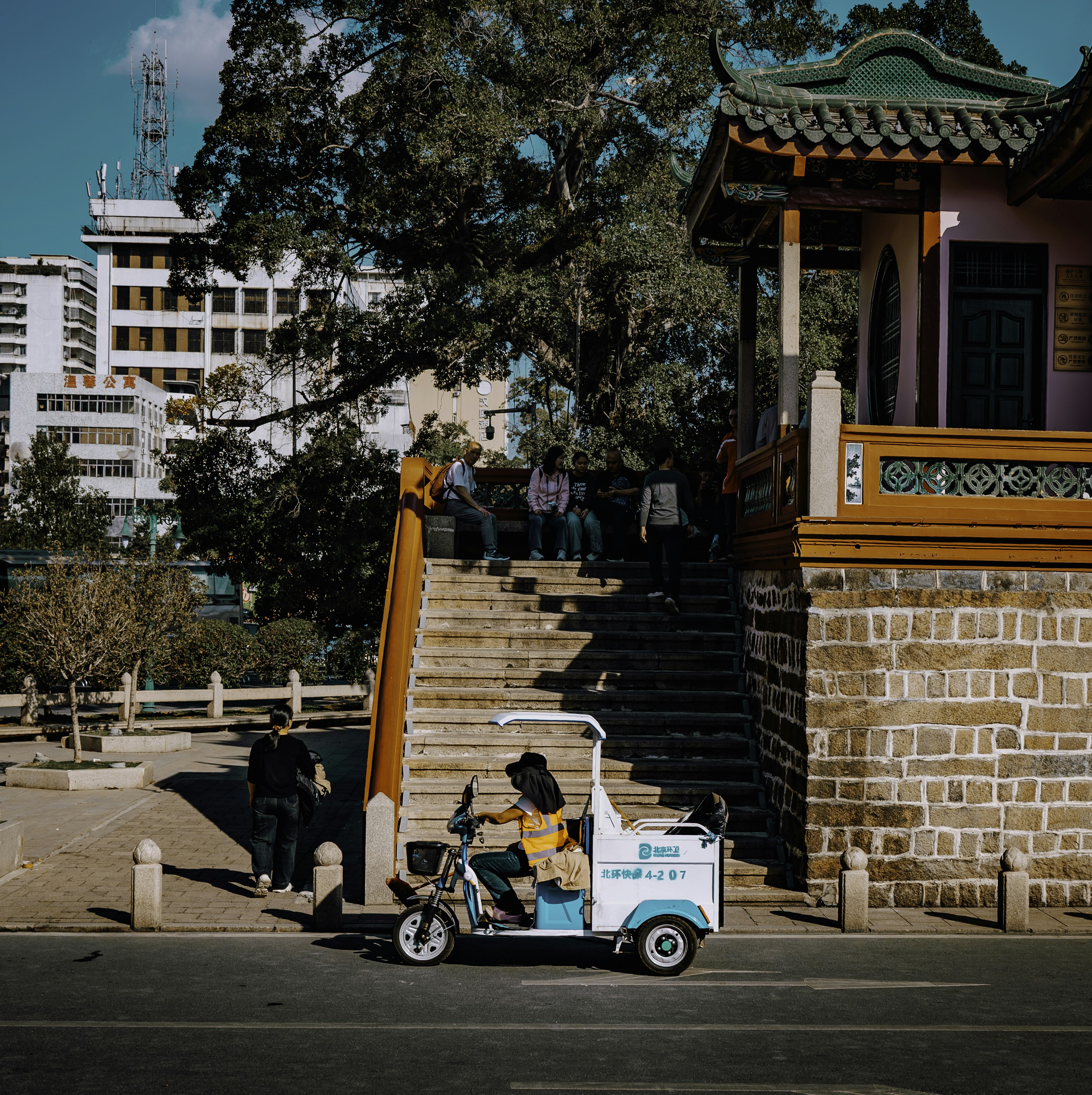 Person riding a small motorized vehicle on a street.