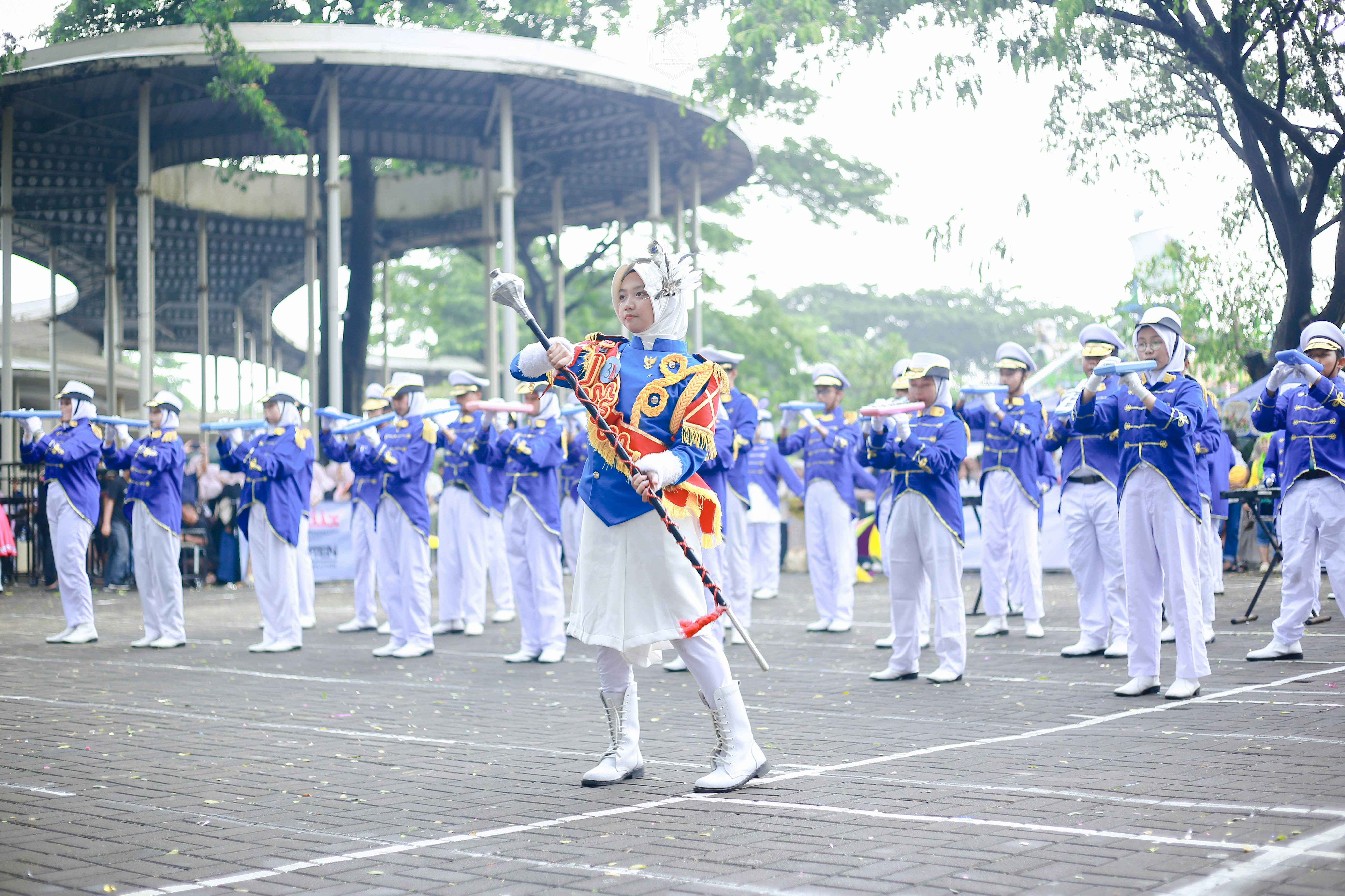Bandmaster in Concert Parade Leads with Bold Blue and Orange Regalia