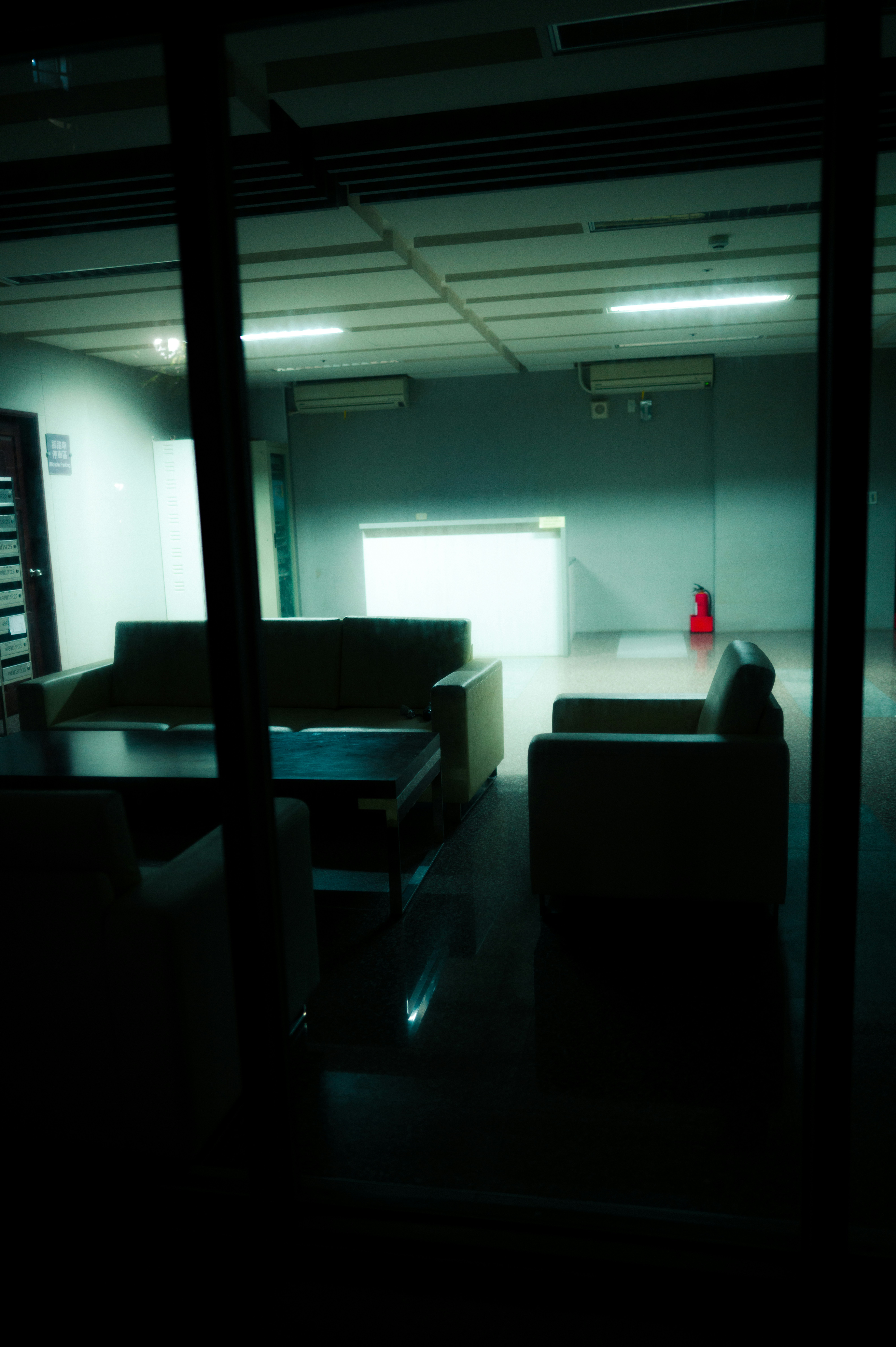 Dim Lobby Nor a Fire Exit: Quiet Interior Under Fluorescent Light