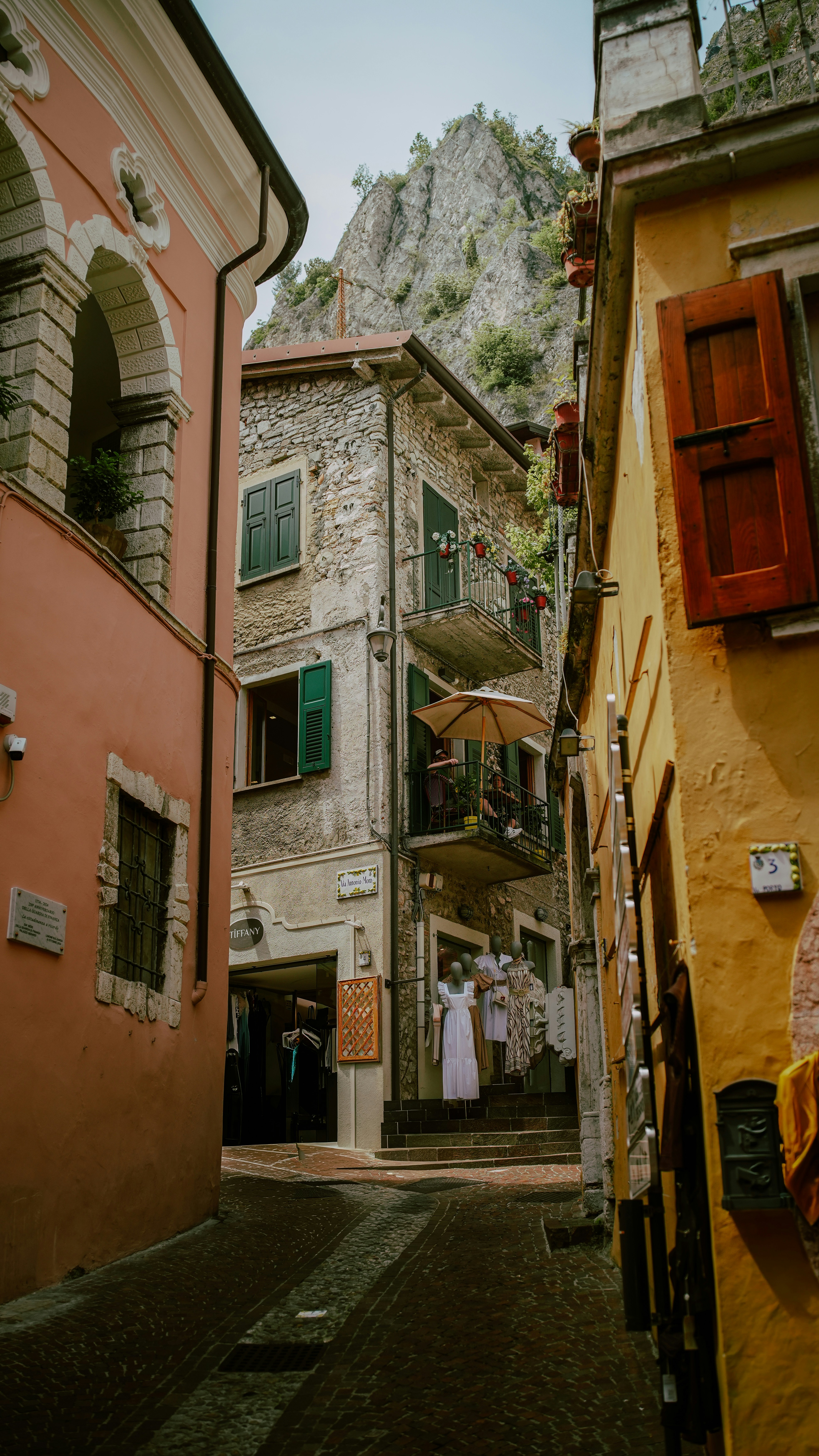 Sunlit Alleyway of Colorful Townhouses with Mountain Backdrop