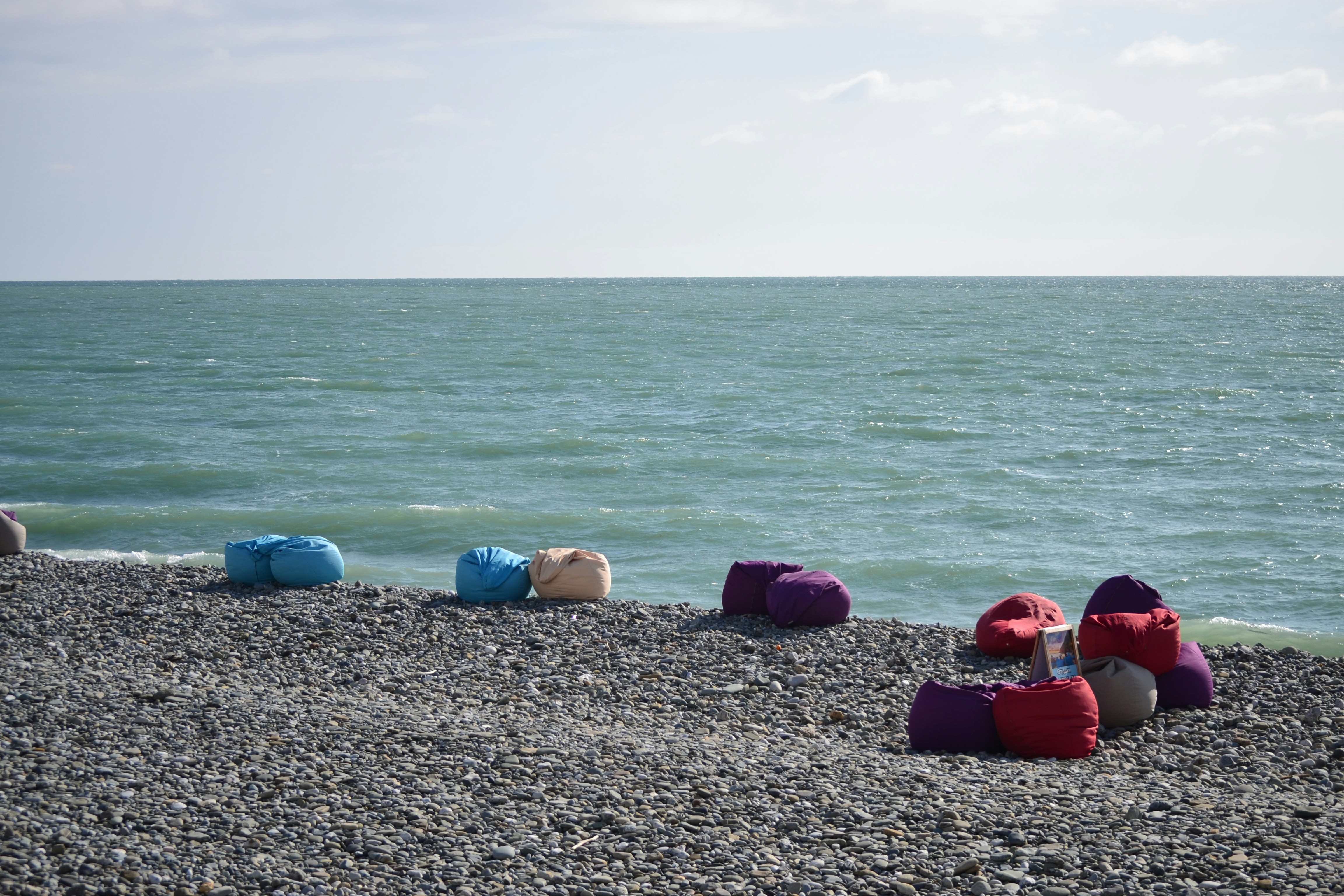 Colorful Bean Bags on a Pebble Beach by a Calm Sea