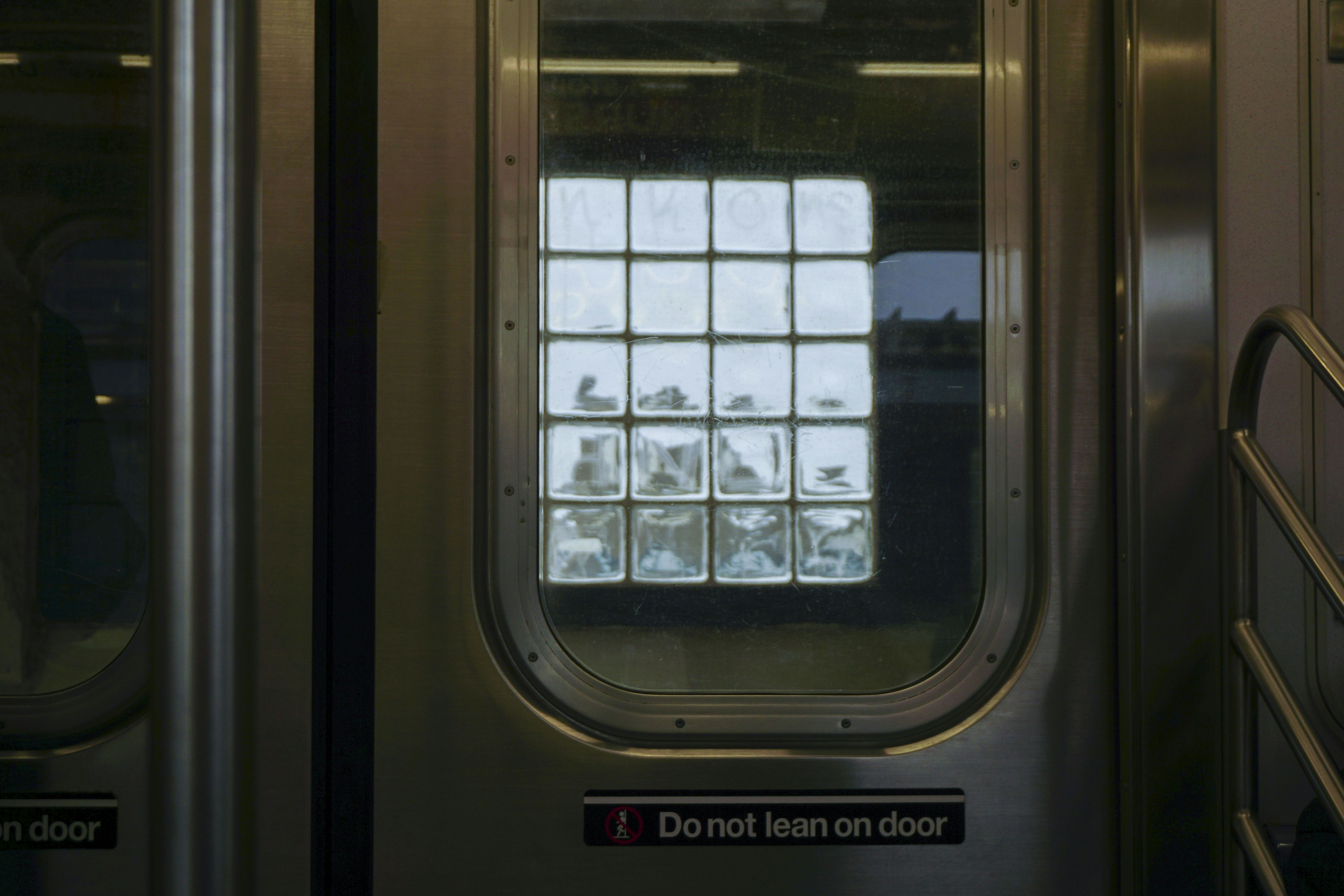 Metro Window Grid: Quiet Reflection on a Train Door